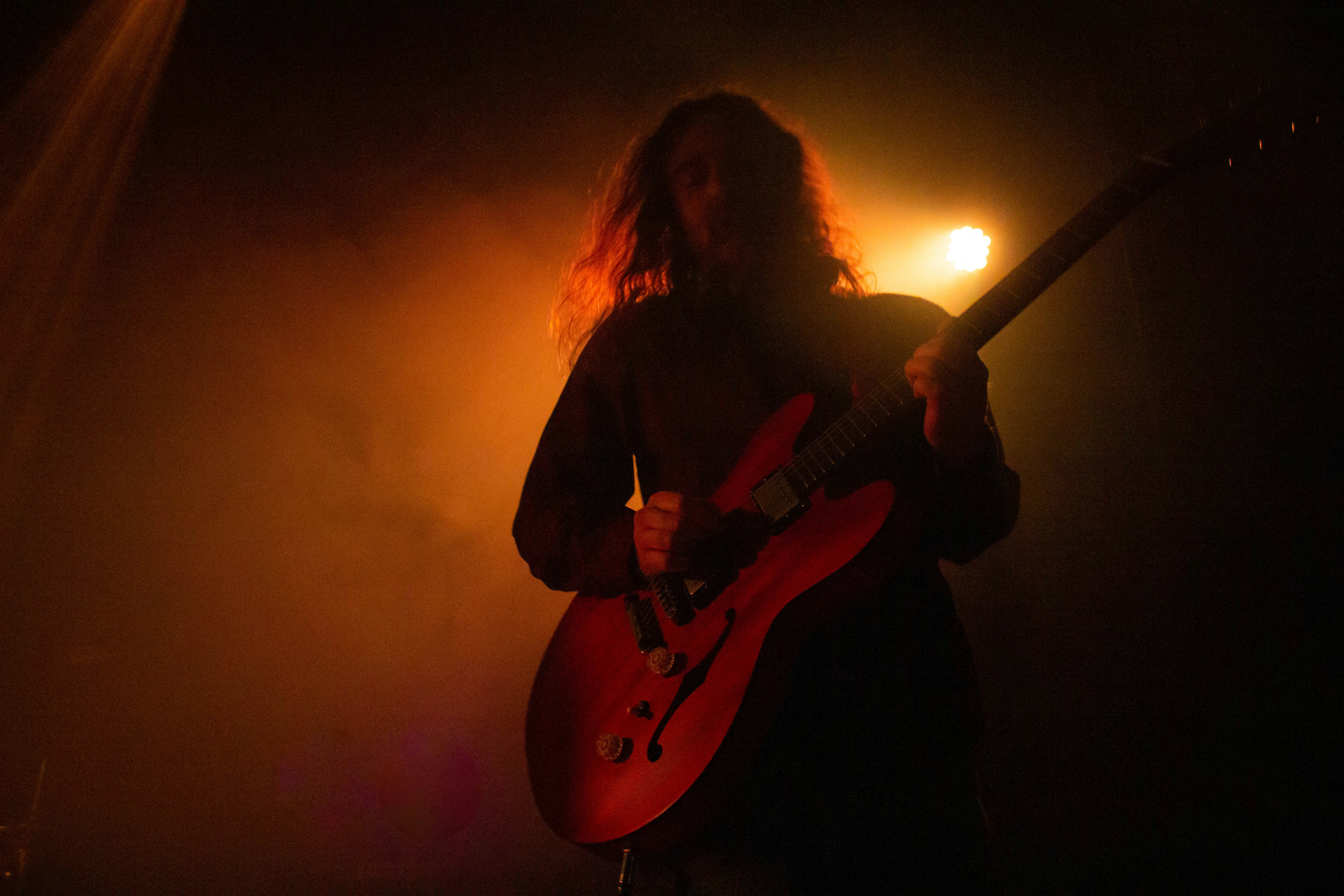 Crimson Axe in Smoke: A Backlit Stage Portrait