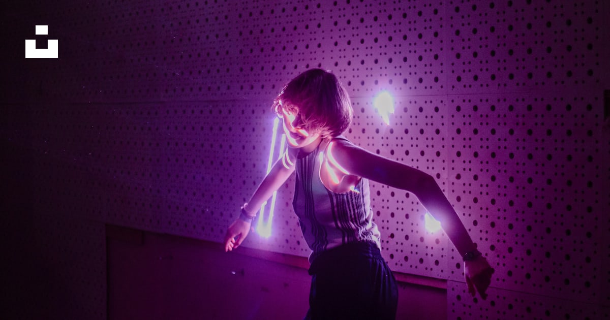 灰色のタンクトップと黒いスカートを着た女性が、ピンクの電球を灯して壁に寄りかかっているの写真 Unsplashの無料紫の写真