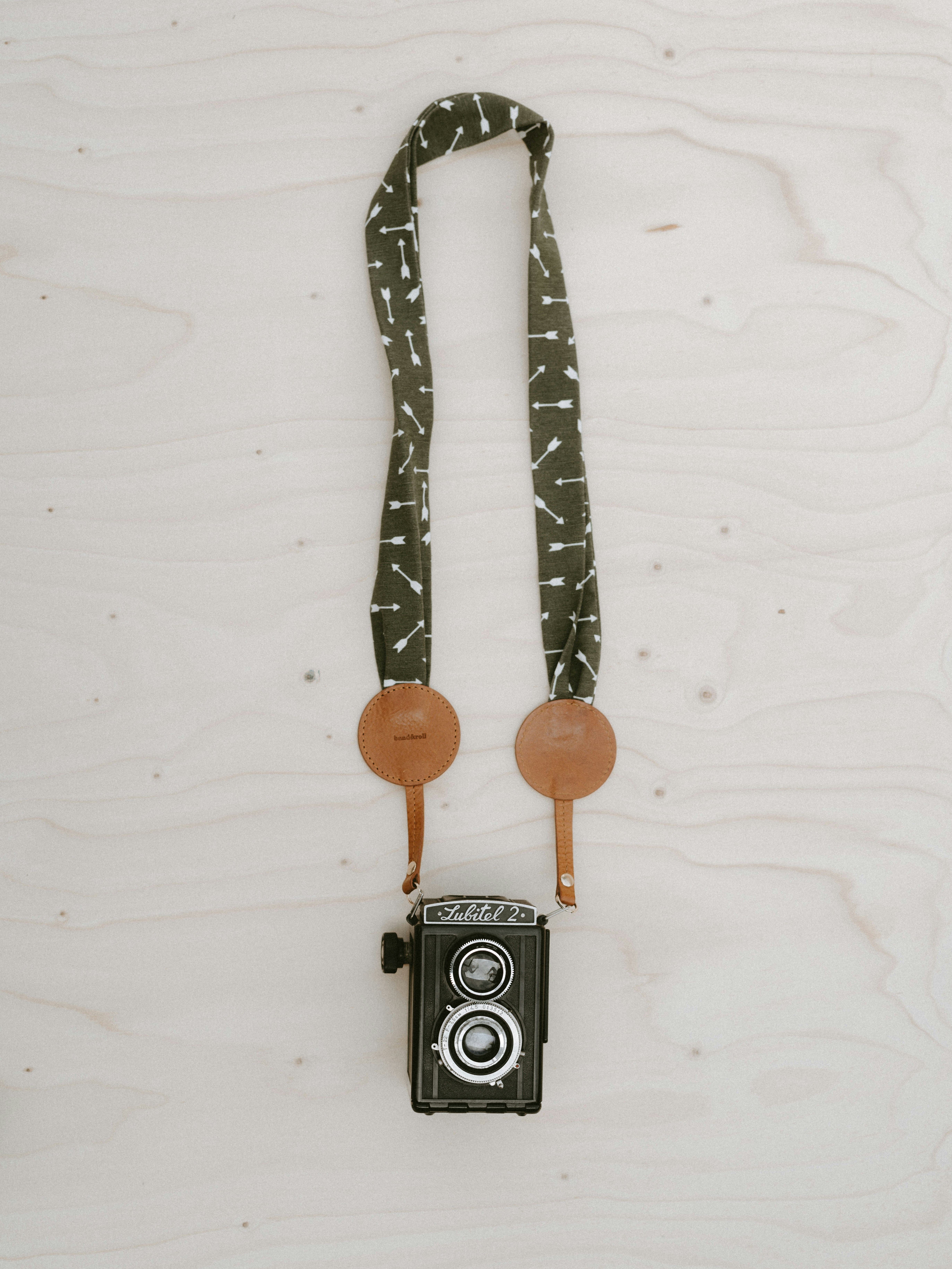 Nostalgic Twin-Lens Snapshot: A Classic Camera Suspended by Leather Straps