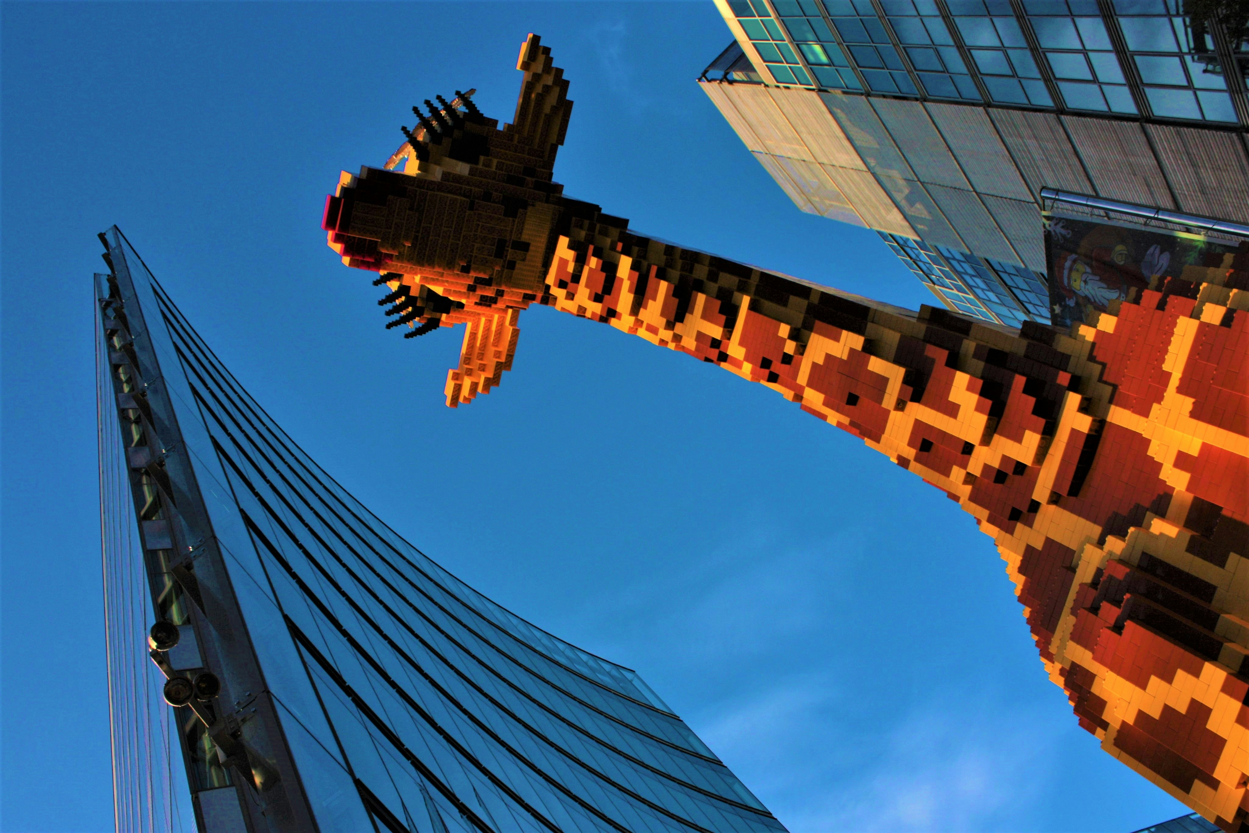Giraffe Sculpture Reaching Toward the Sky Amid Modern Architecture