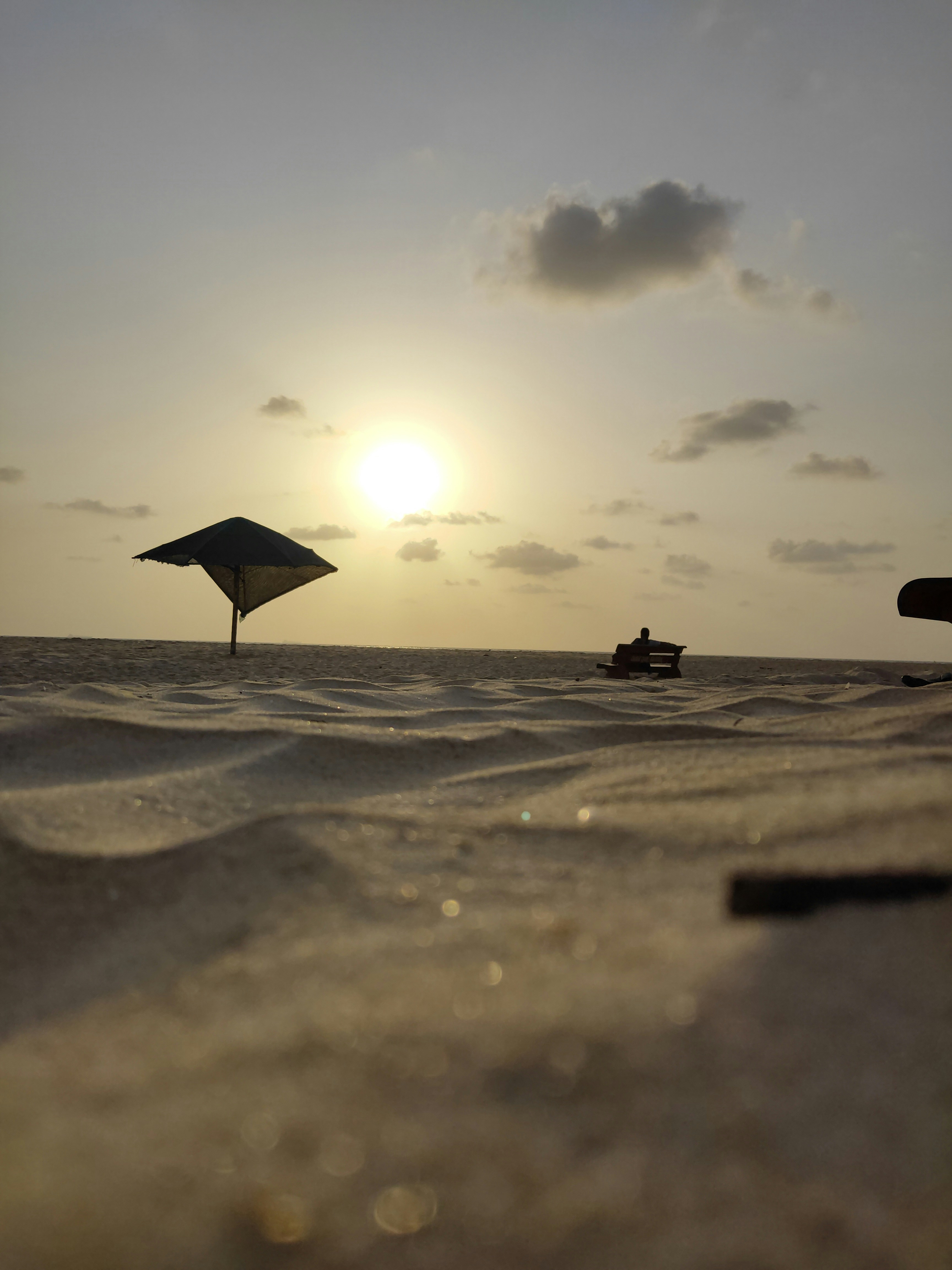 Sunlit Shoreline: A Quiet Moment by the Umbrella