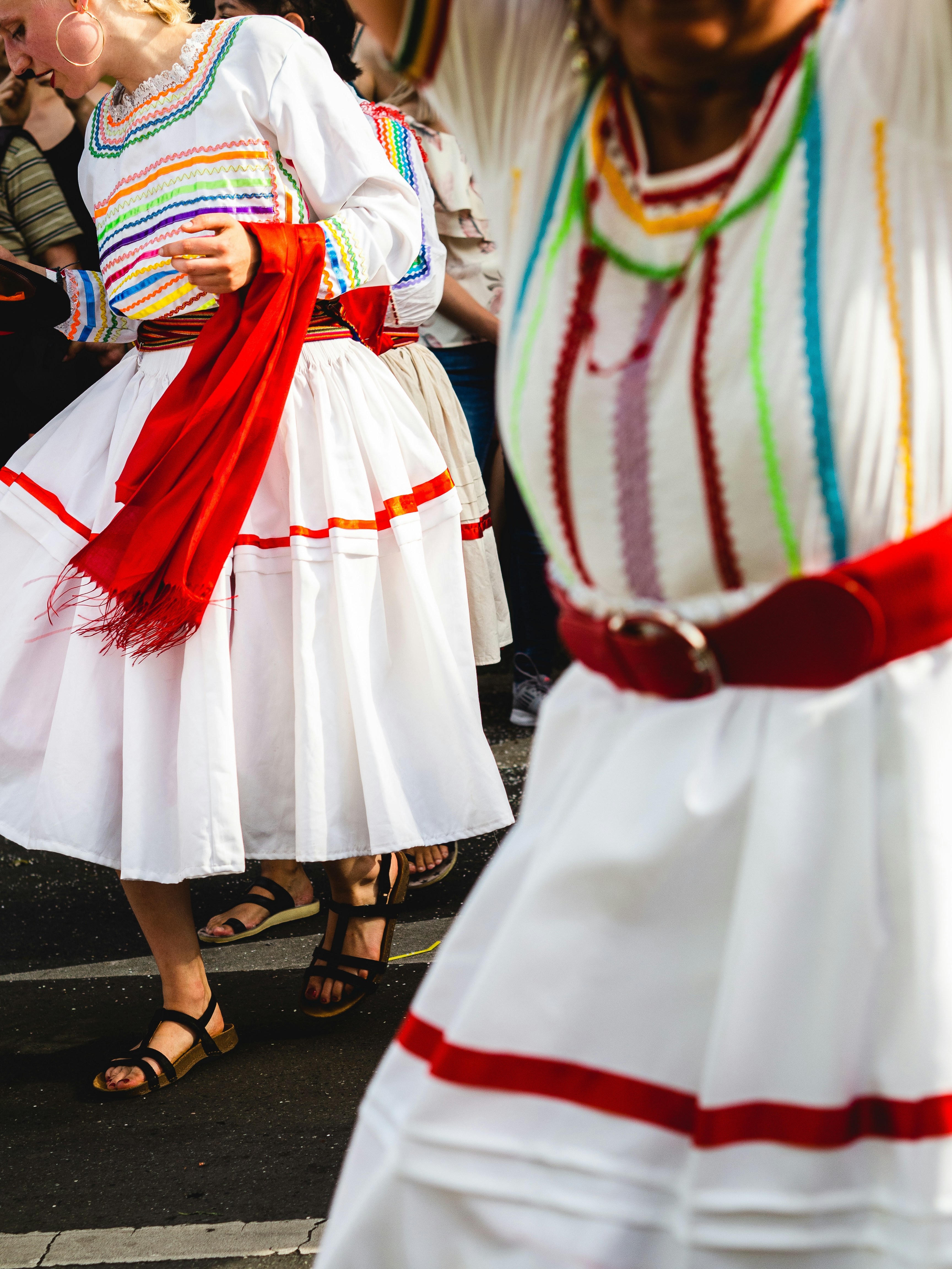 Participants in traditional attire dance joyfully, showcasing vibrant colors and cultural heritage during a lively festival.