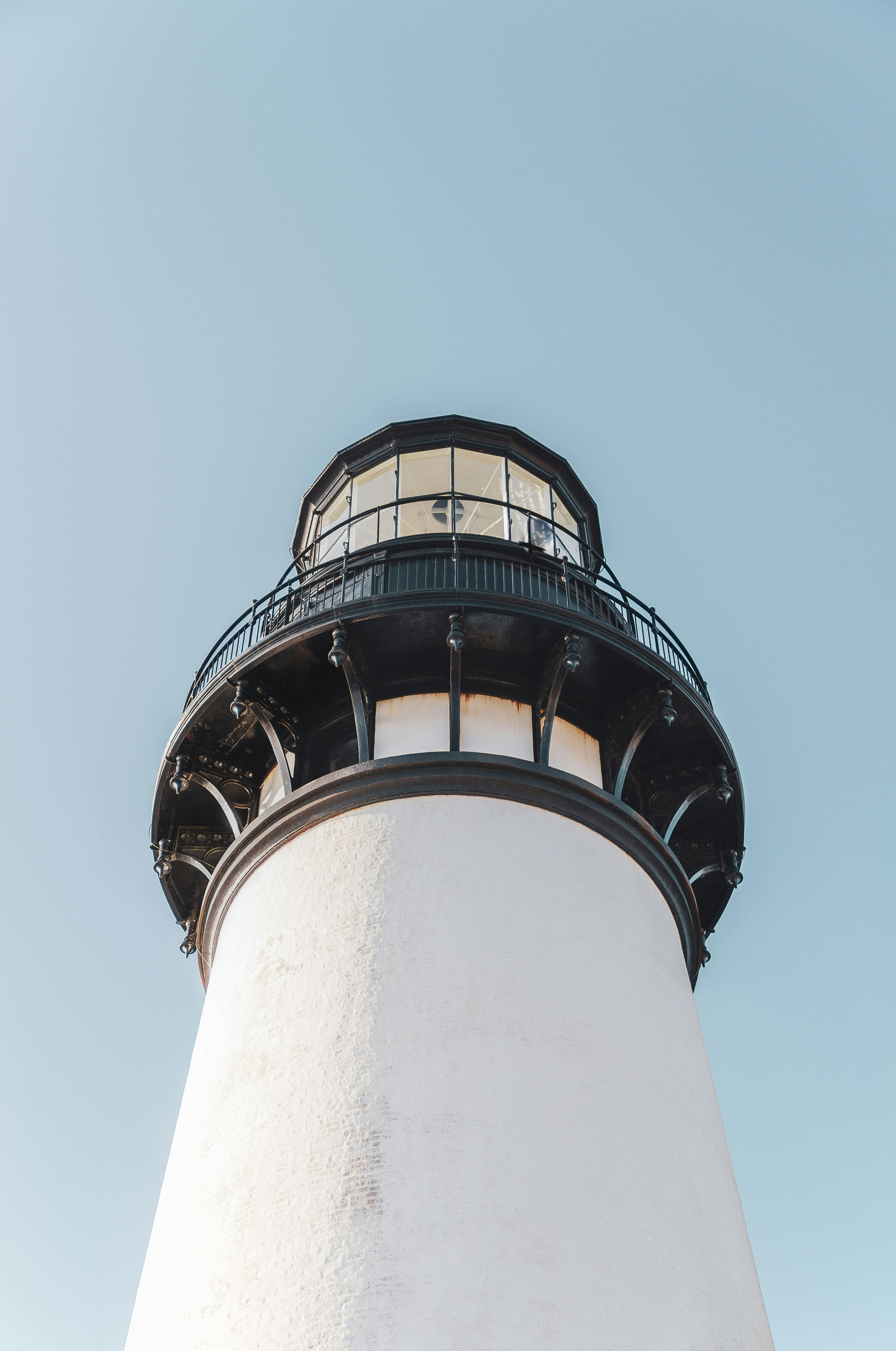 Lighthouse at the seashore on a beautiful day. | architectural photography of white and black lighthouse