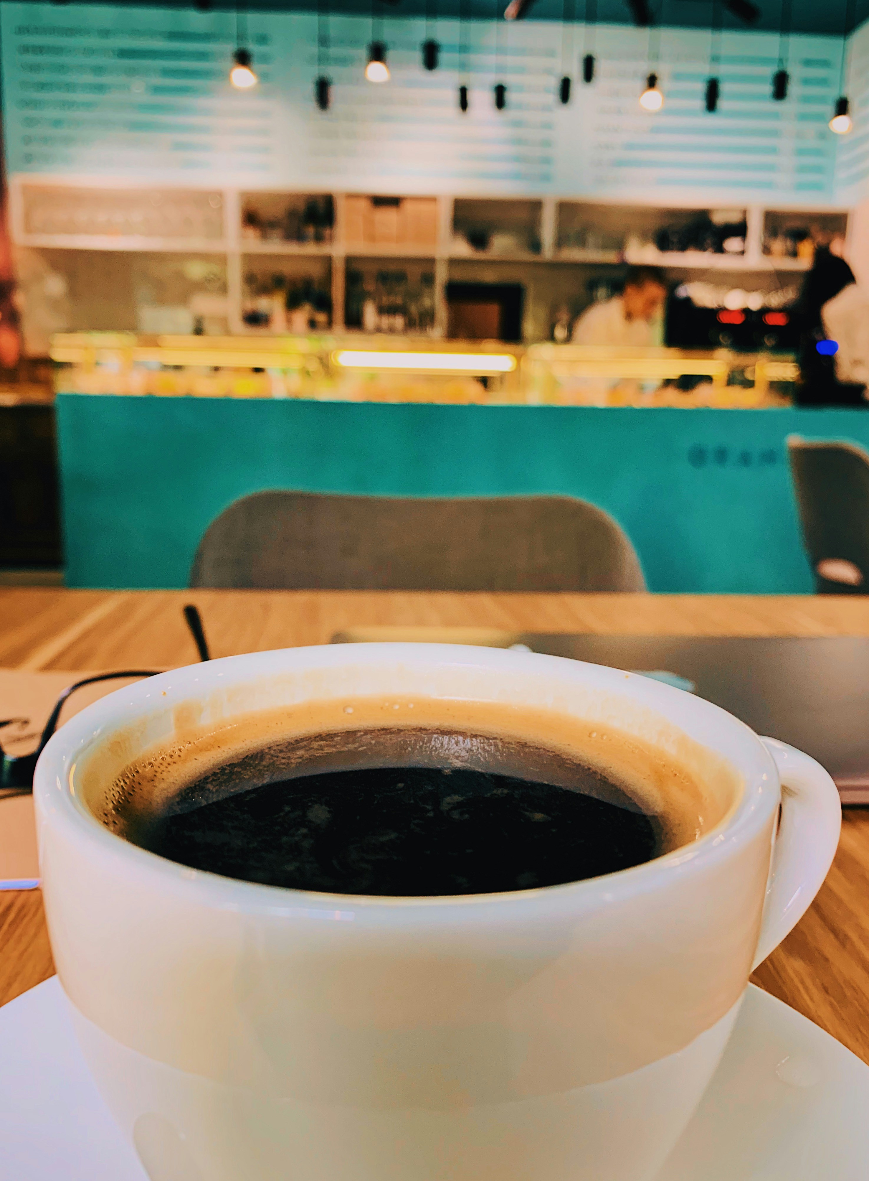 Sip at the Counter: A Café Moment Blurred by Steam and Light