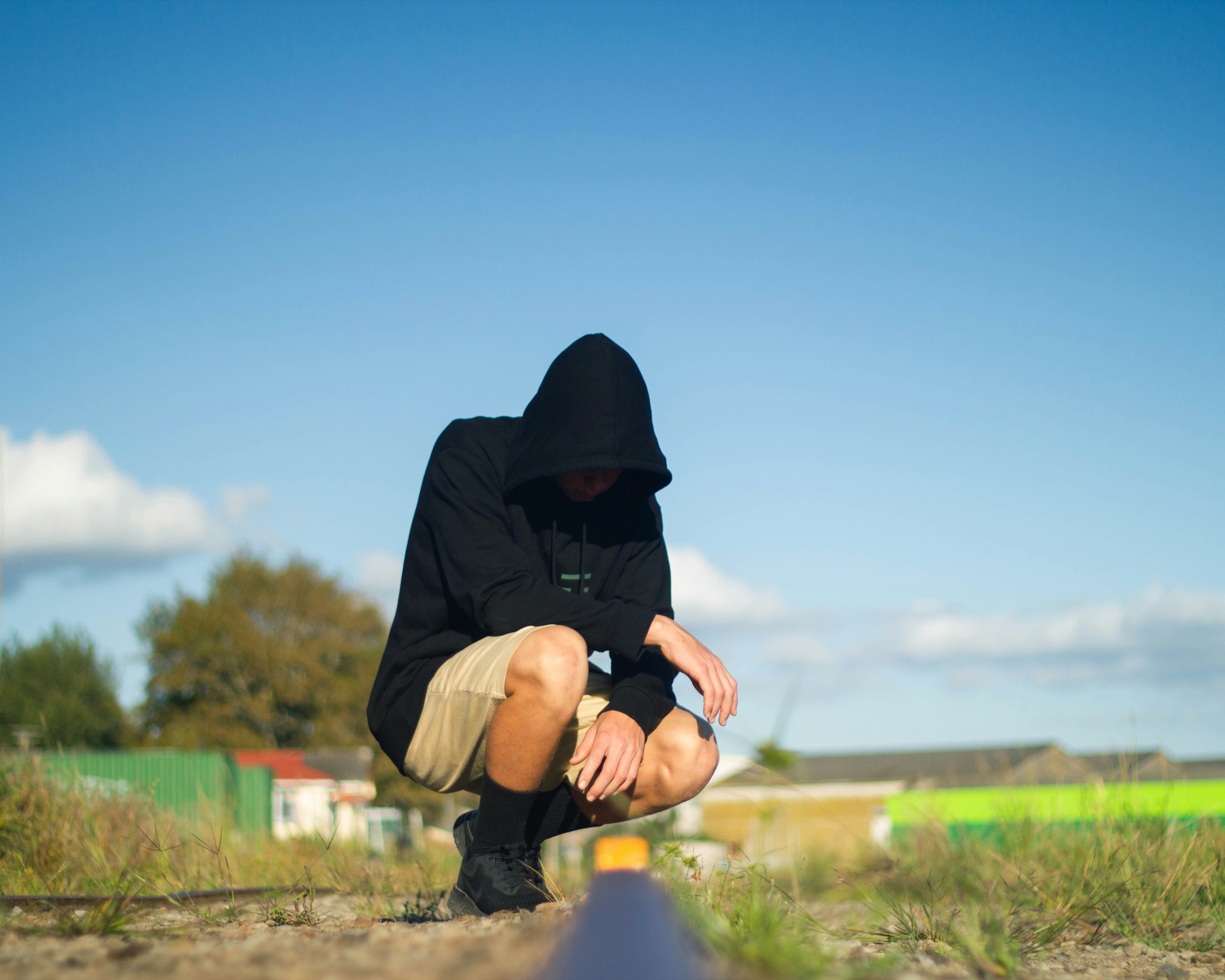 Hooded Figure at Ground Level: A Quiet Study in Stance and Shadow