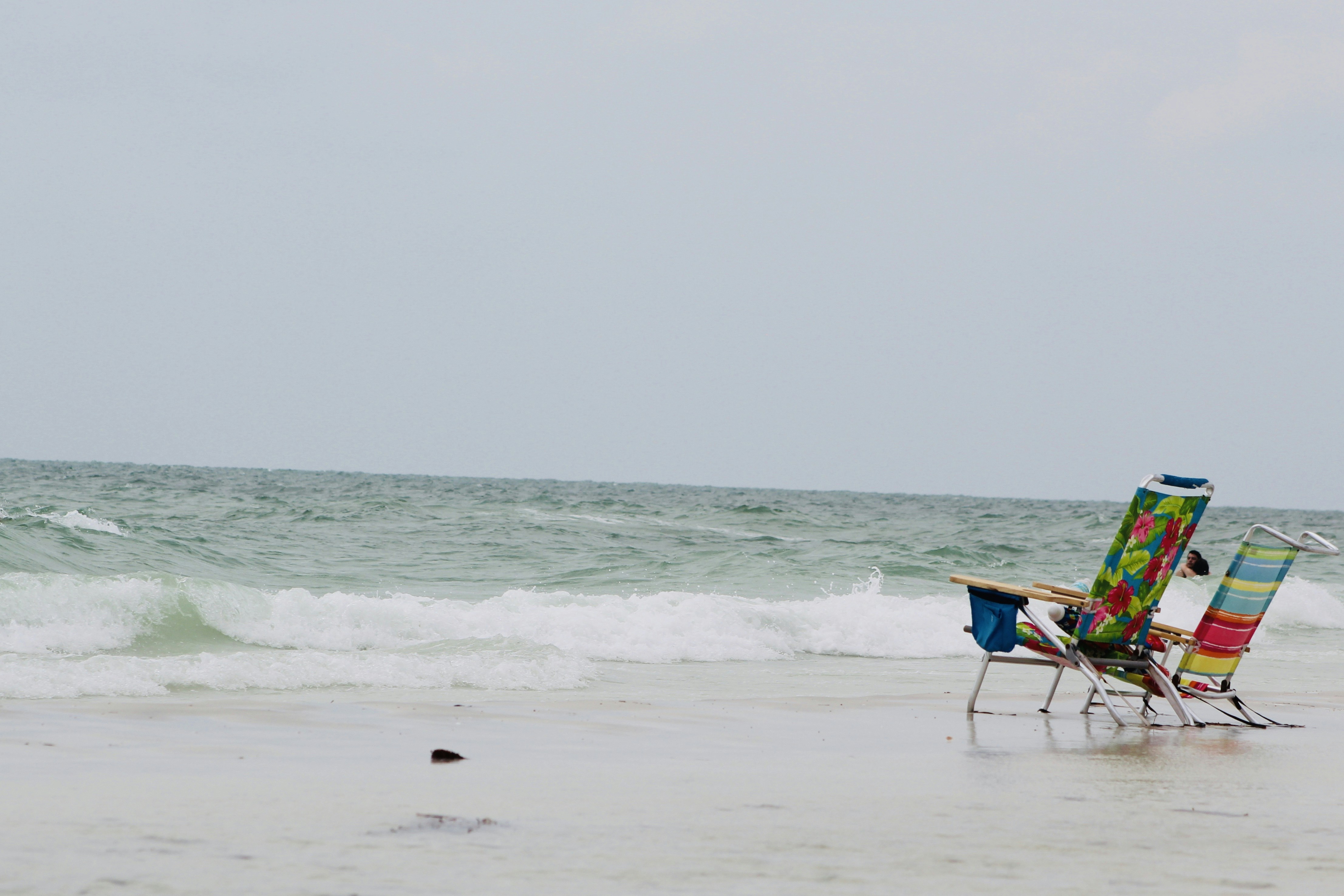 Sunlit Beach Chairs Turn Toward A Serene Sea
