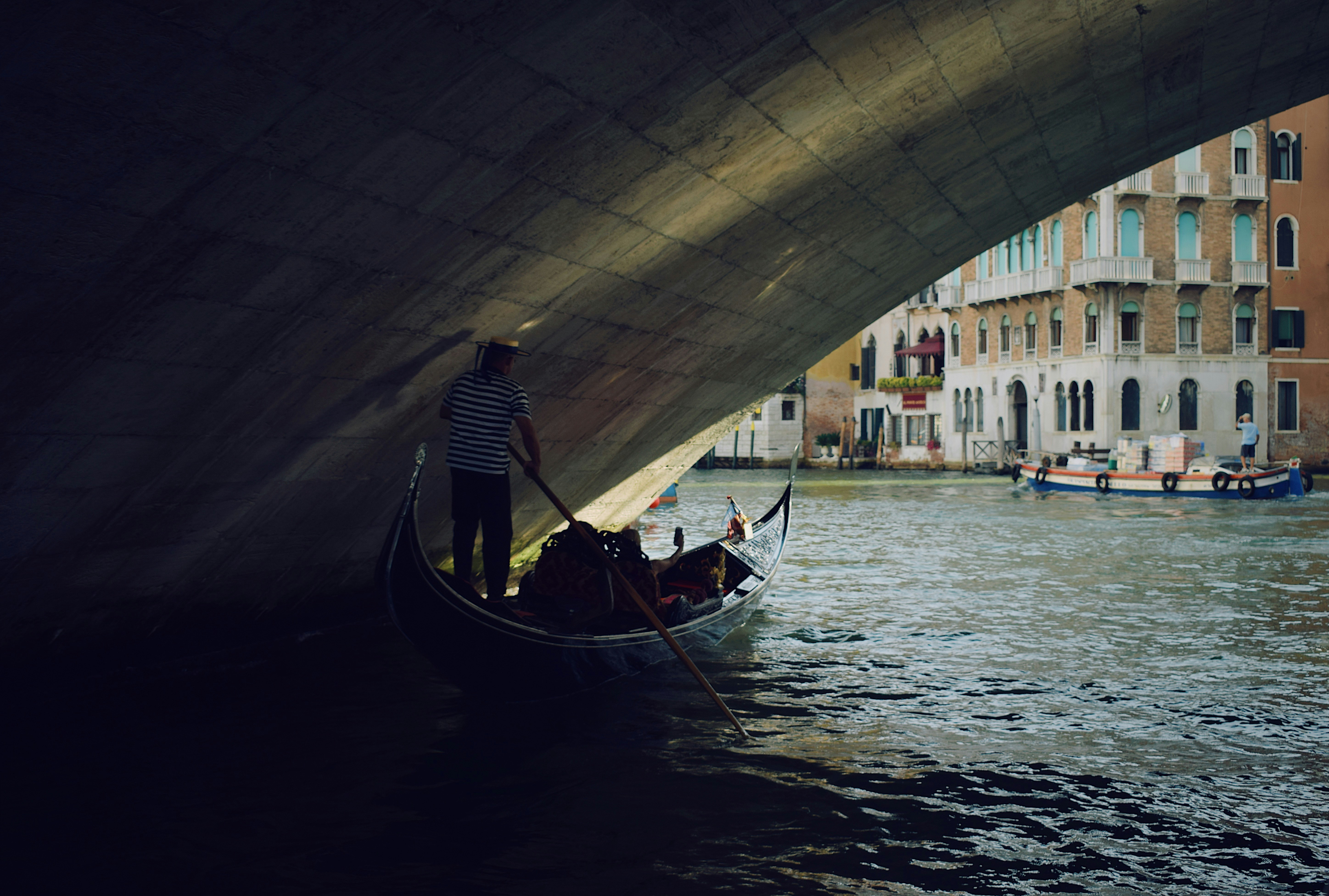 Gondola under a Venetian Arch: Quiet Drift Through Sunlit Facades