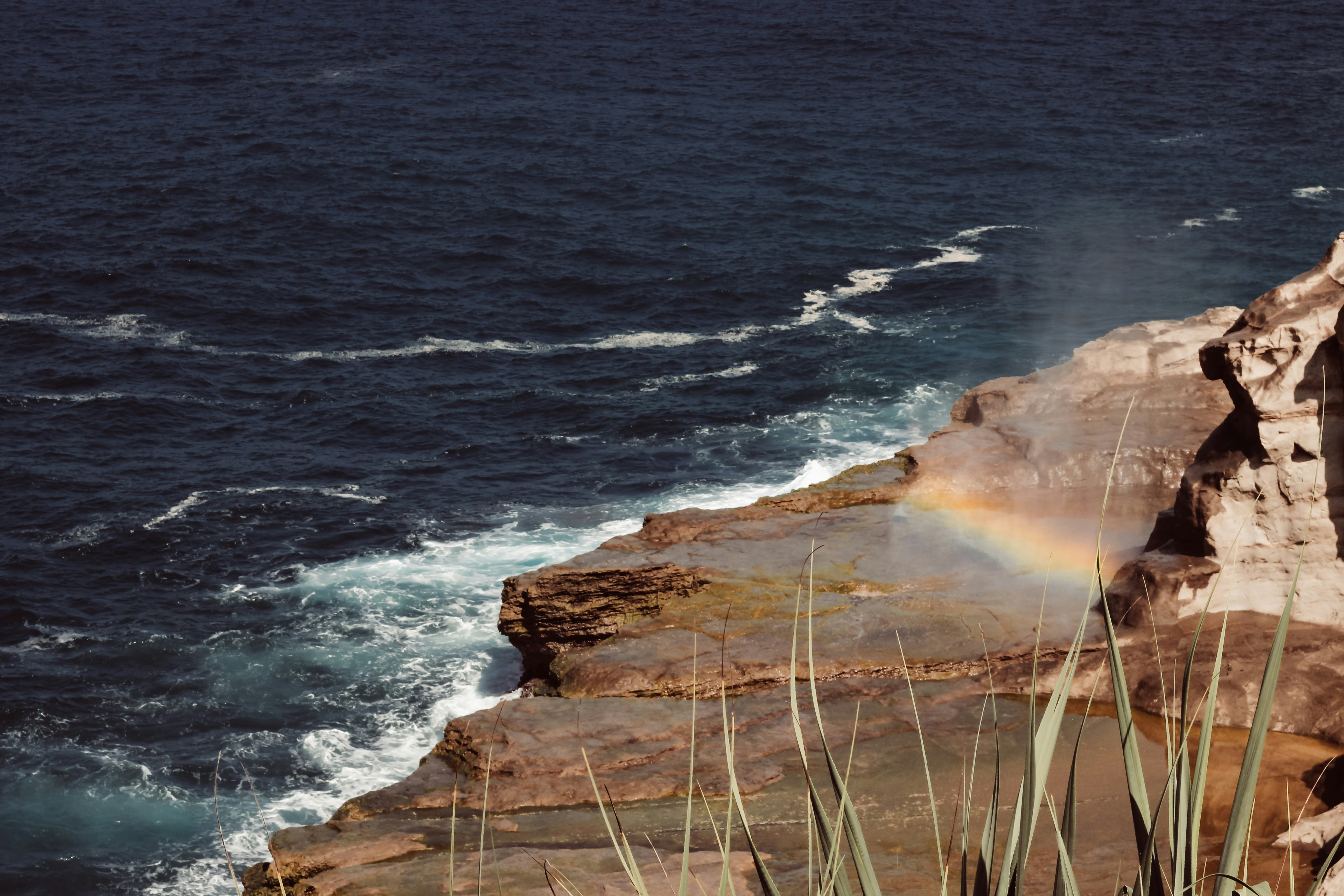 Rainbow Edge: Cliffside Vista with Sea Spray and Light