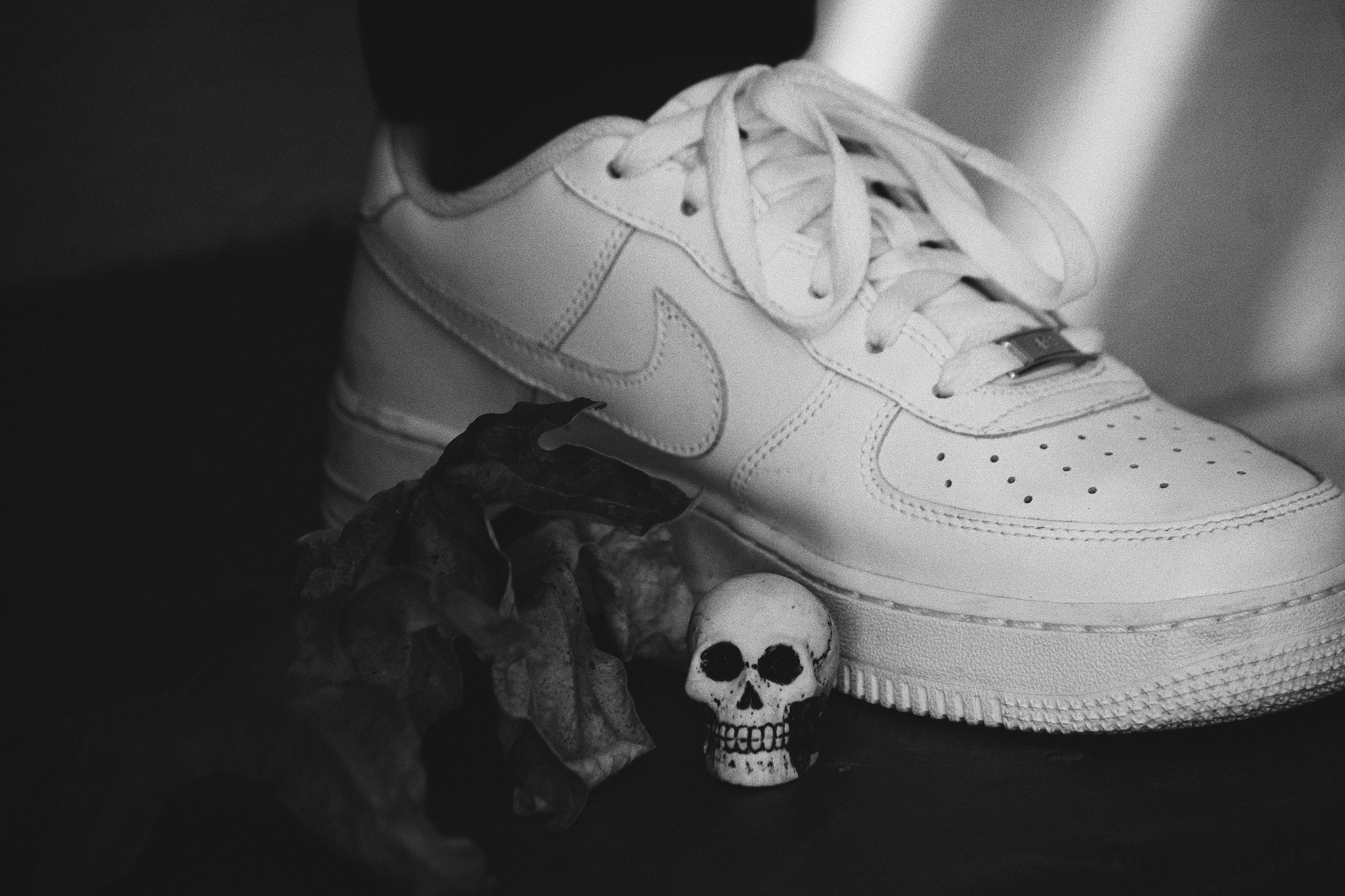 Skull and Sole in Mono: Quiet Contrast Beneath a White Sneaker