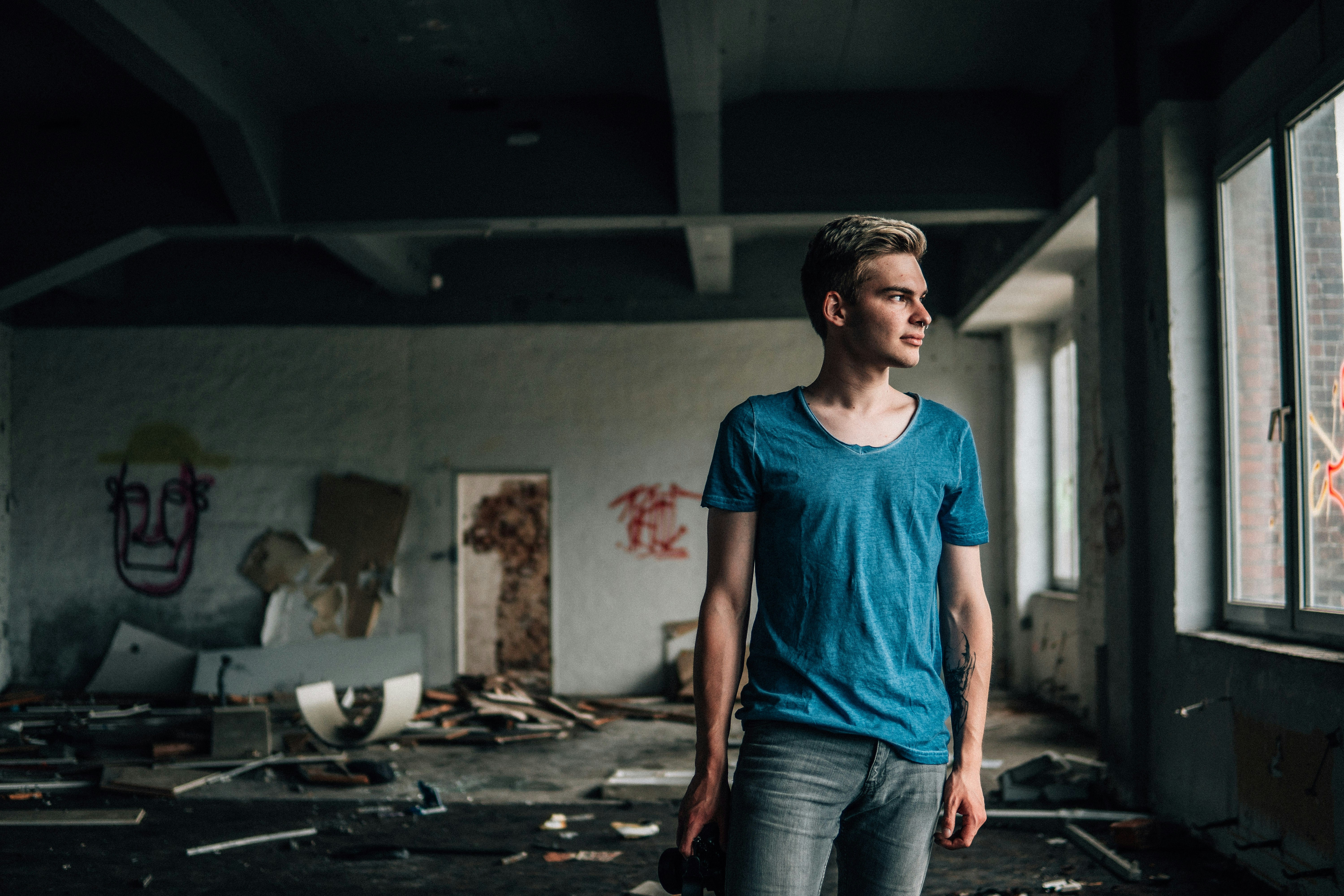 Man wearing teal top standing near window inside room photo – Free ...