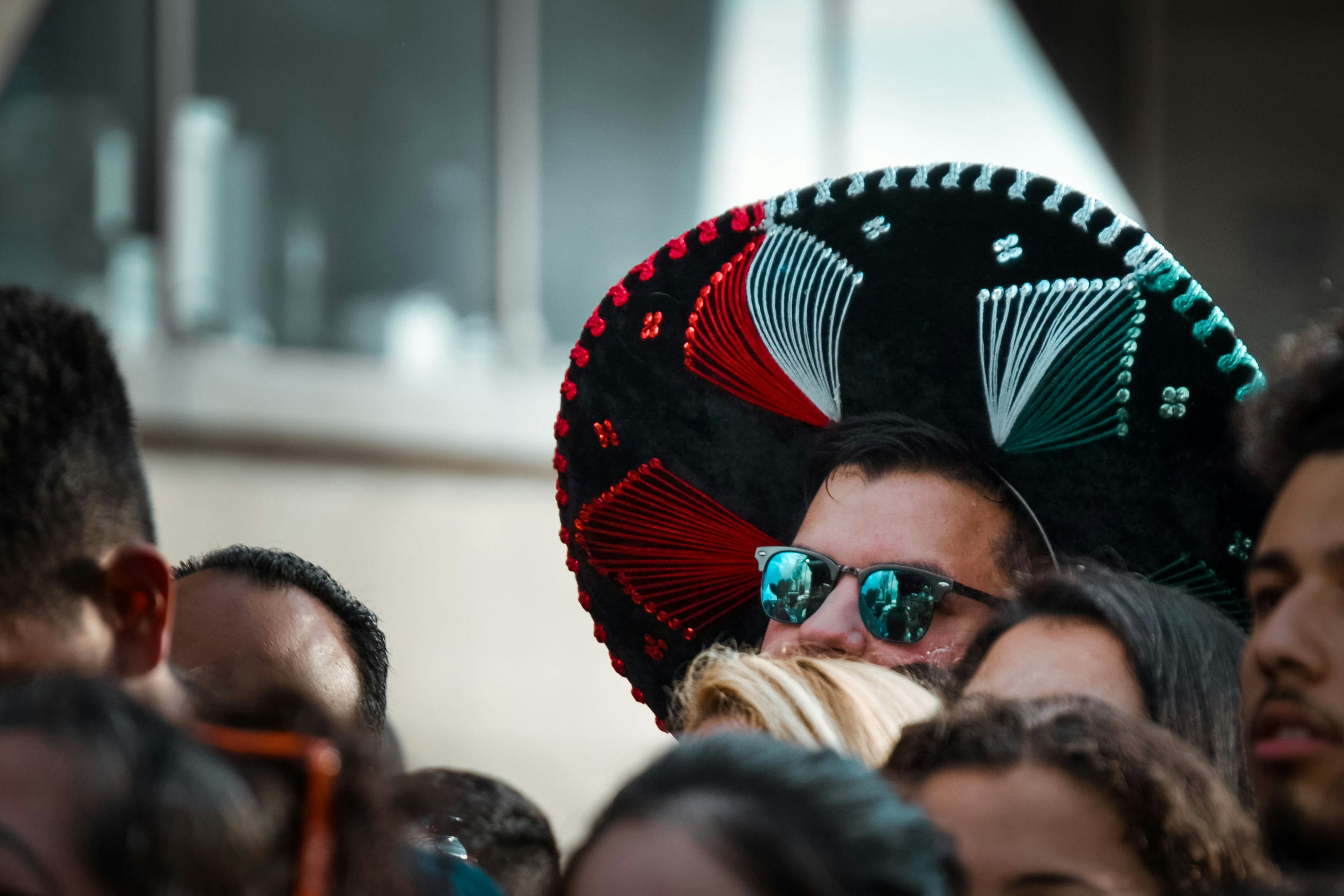 Fiesta Hat Focal: A Glistening Sunglasses Portrait in a Crowded Moment