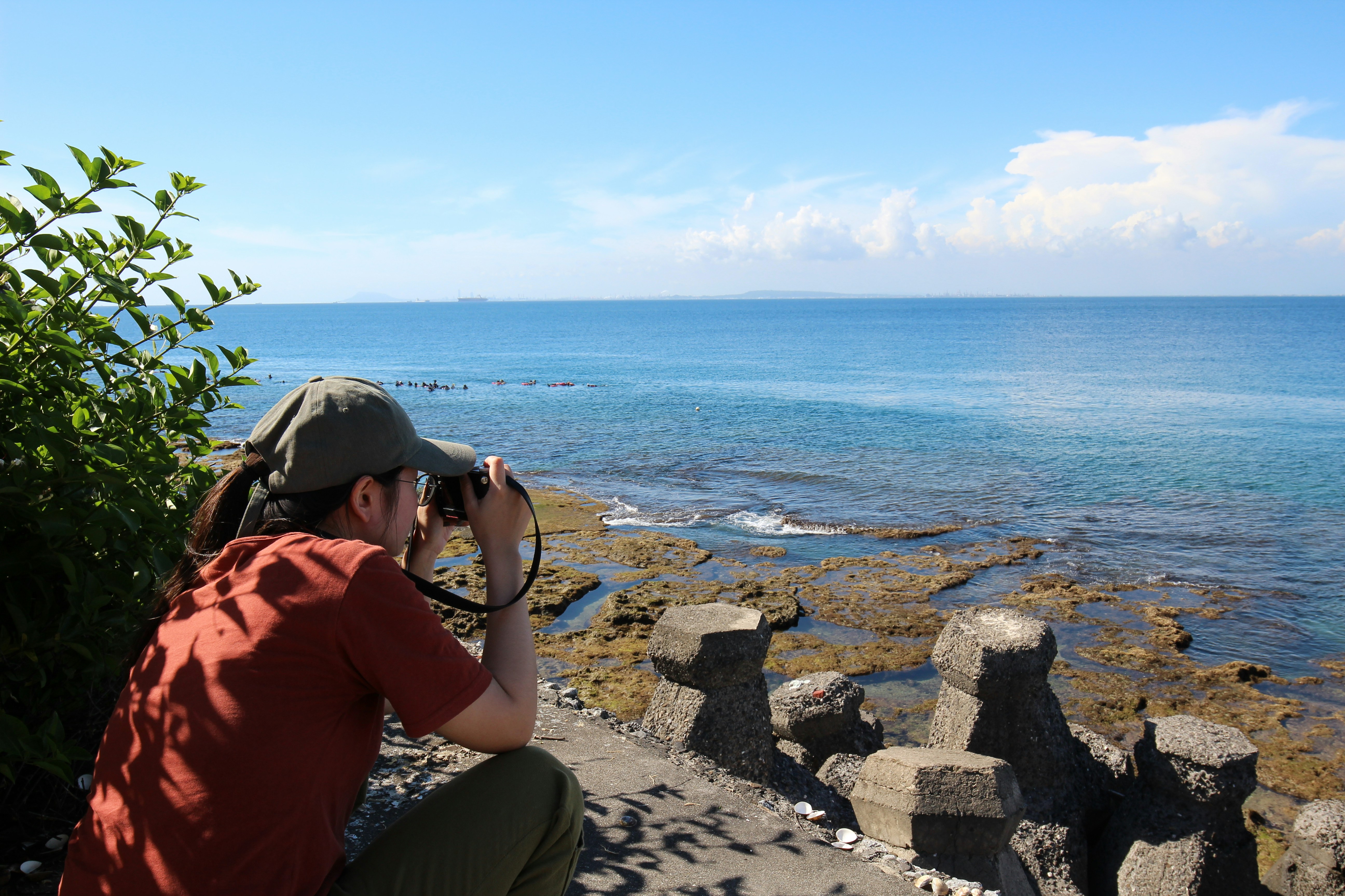 Edge of Focus: Photographer Framing the Quiet Sea from a Rocky Promenade