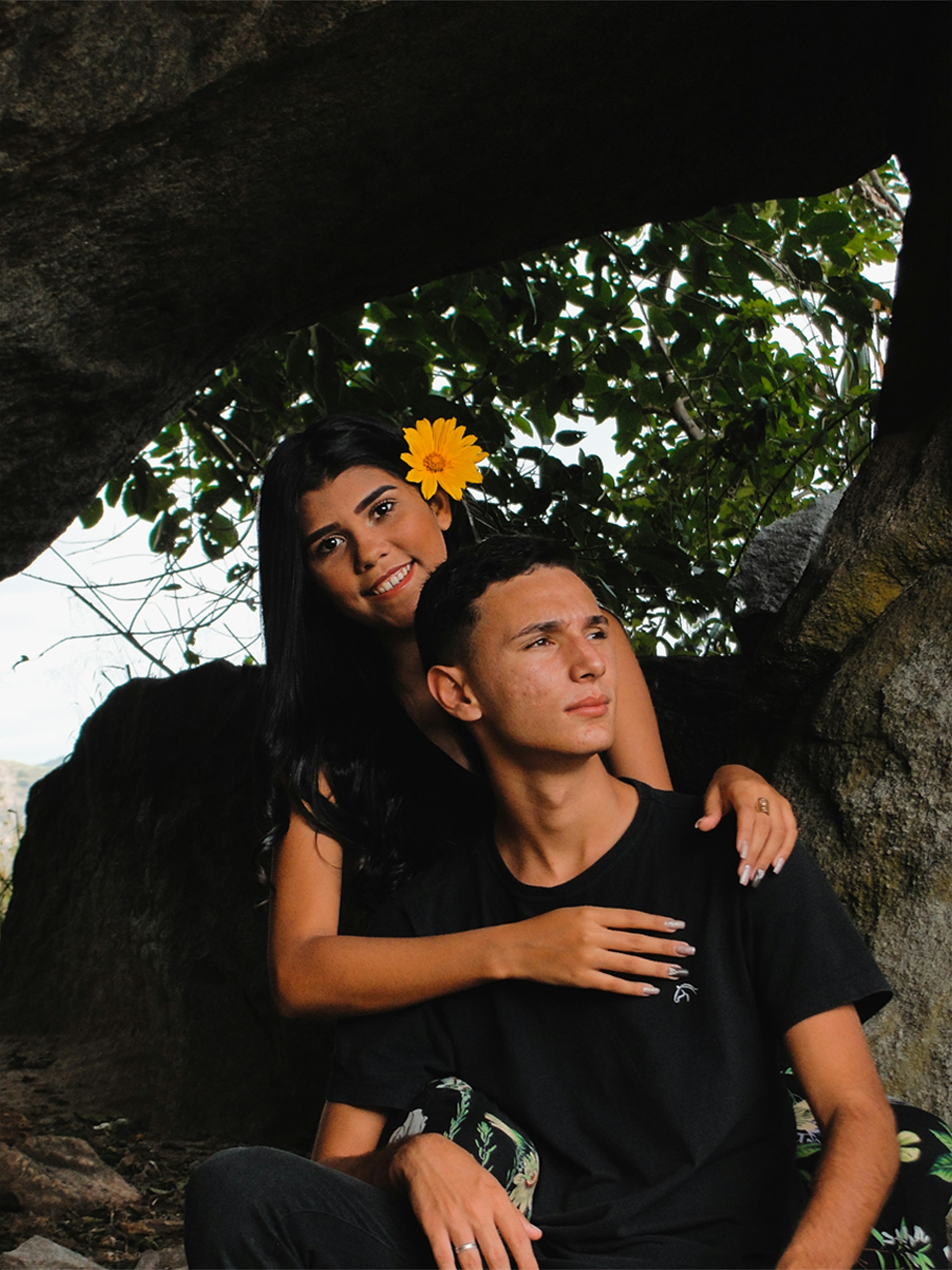 Smiling woman sitting and hugging man looking his right side beside ...