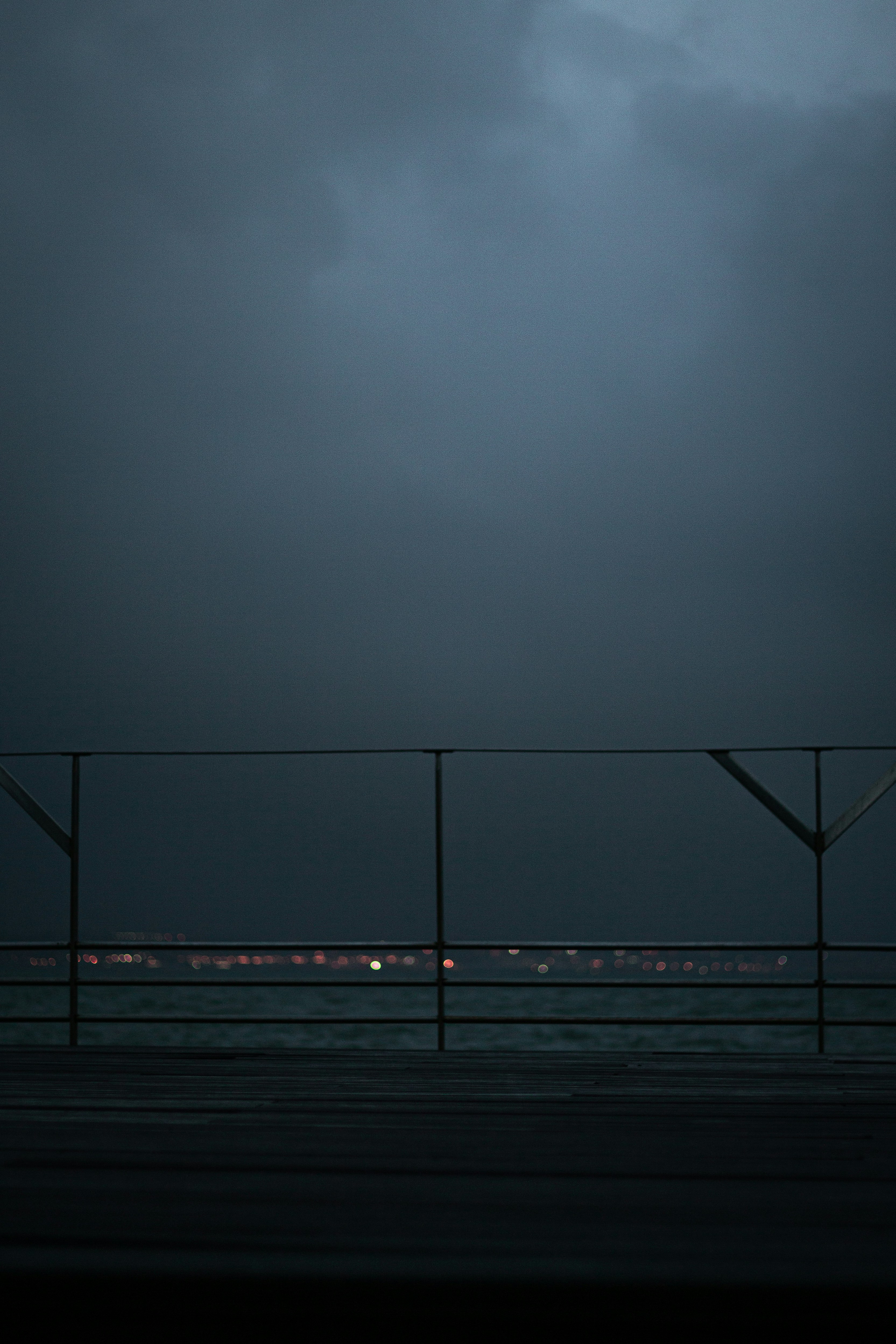 Horizon in Haze: A Quiet Pier Framed by Stormy Skies