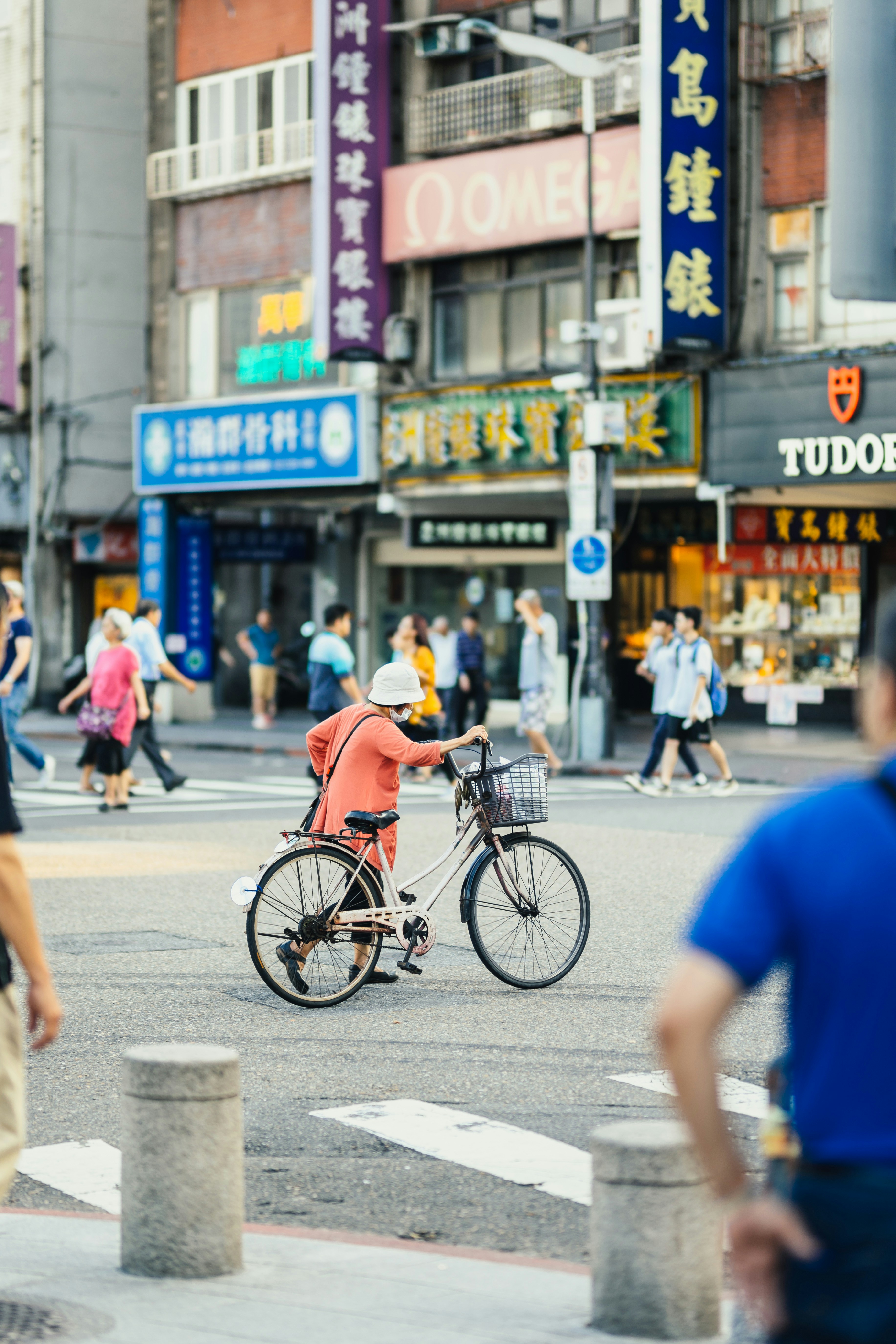 Woman in orange walking with a bike at an intersection photo – Free ...