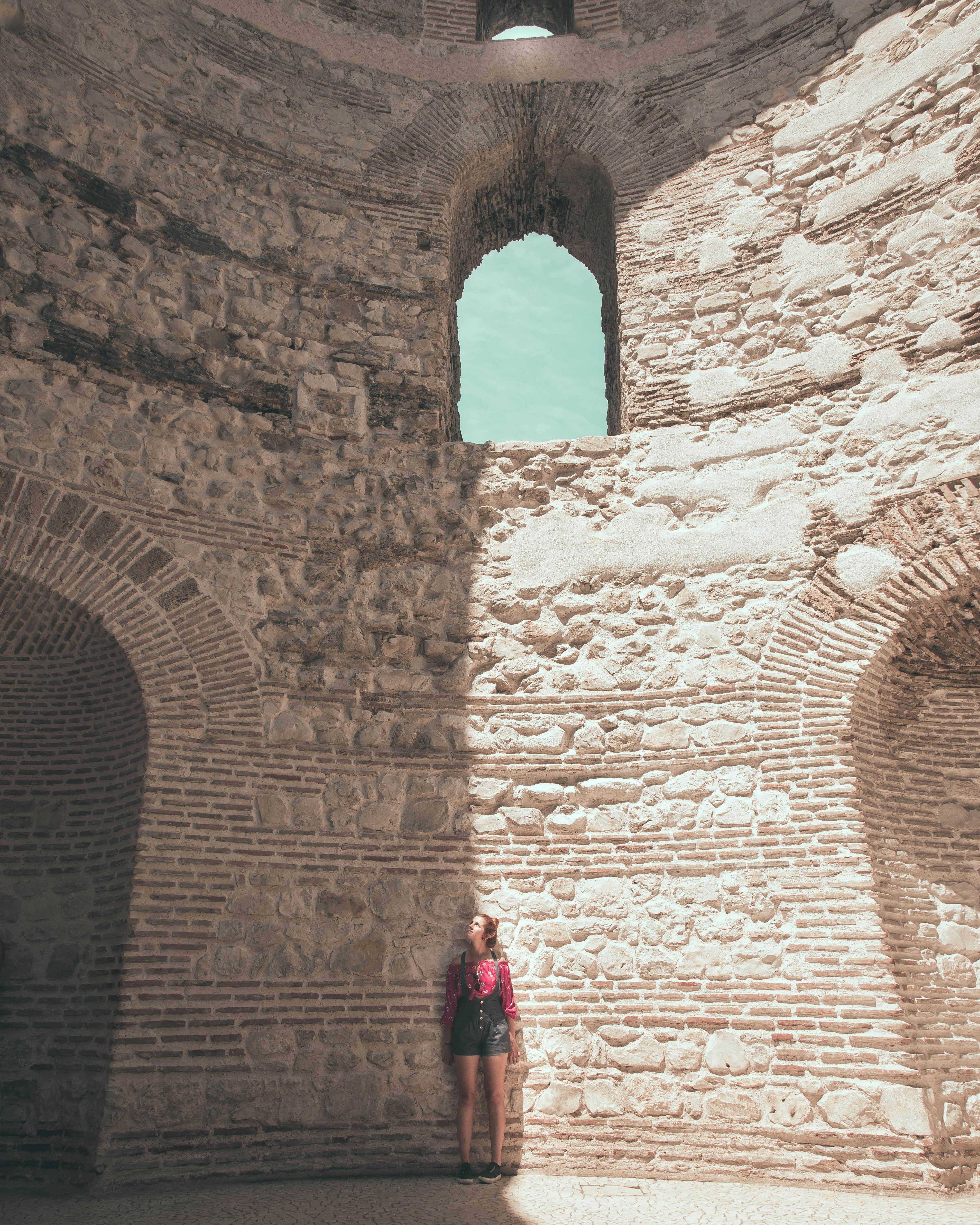 Ringed Fortress Portrait: A lone figure beneath the skylight in an ancient circular ruin