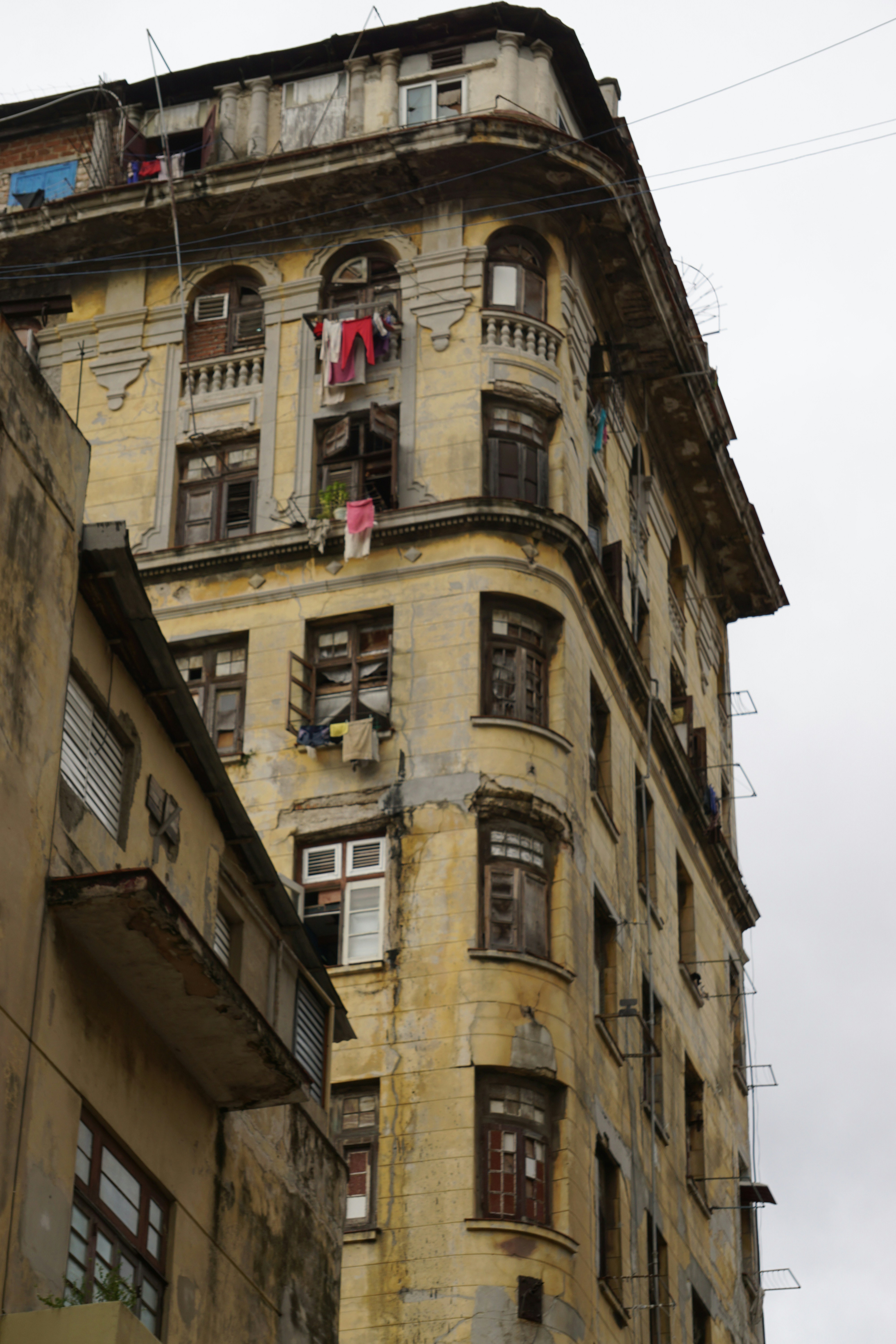 Laundry Lines on a Weathered Corner: A Curved Facade Echoes the City