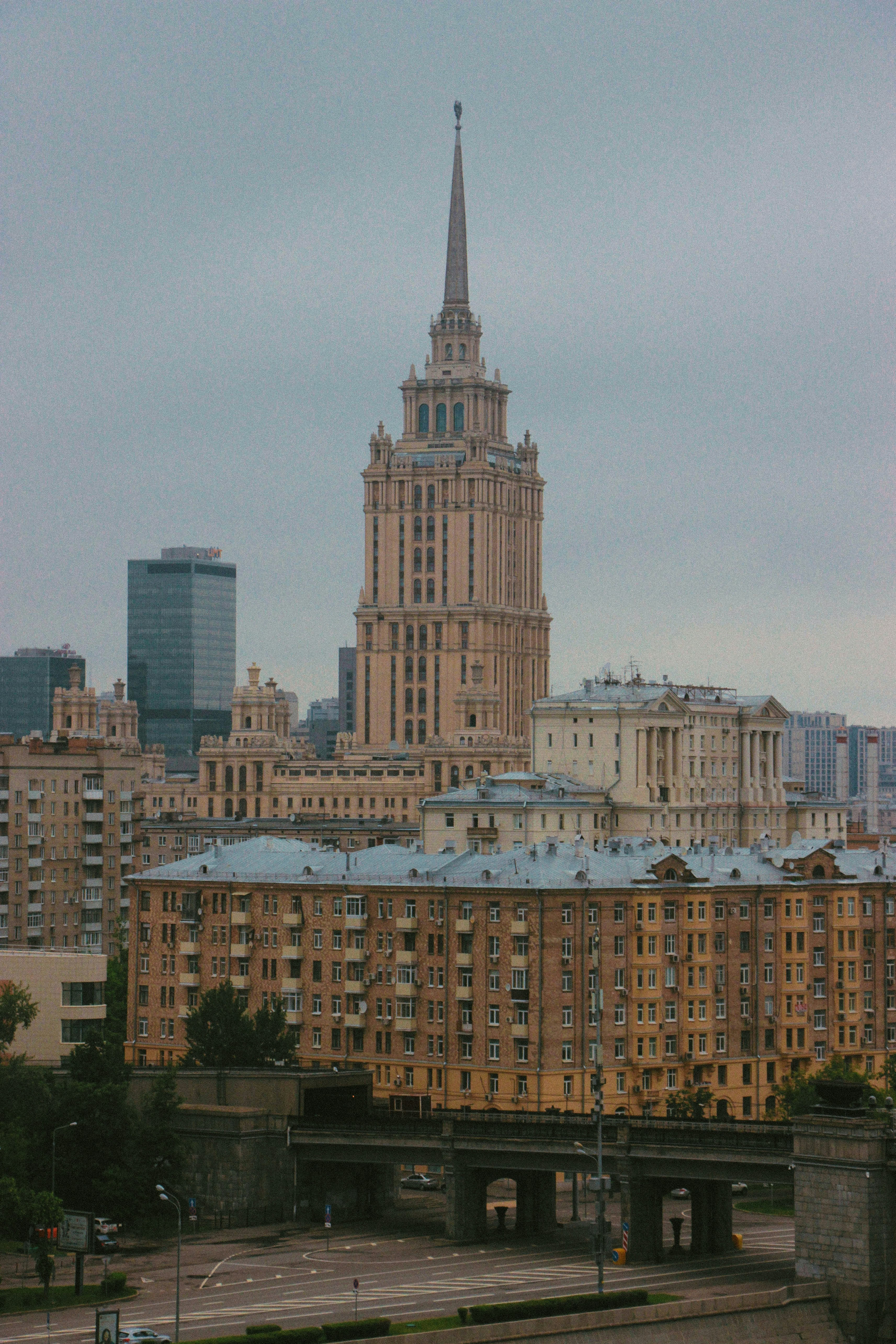 Imposing Soviet-era skyscraper towers over a cityscape, showcasing a blend of architectural styles against a moody sky.