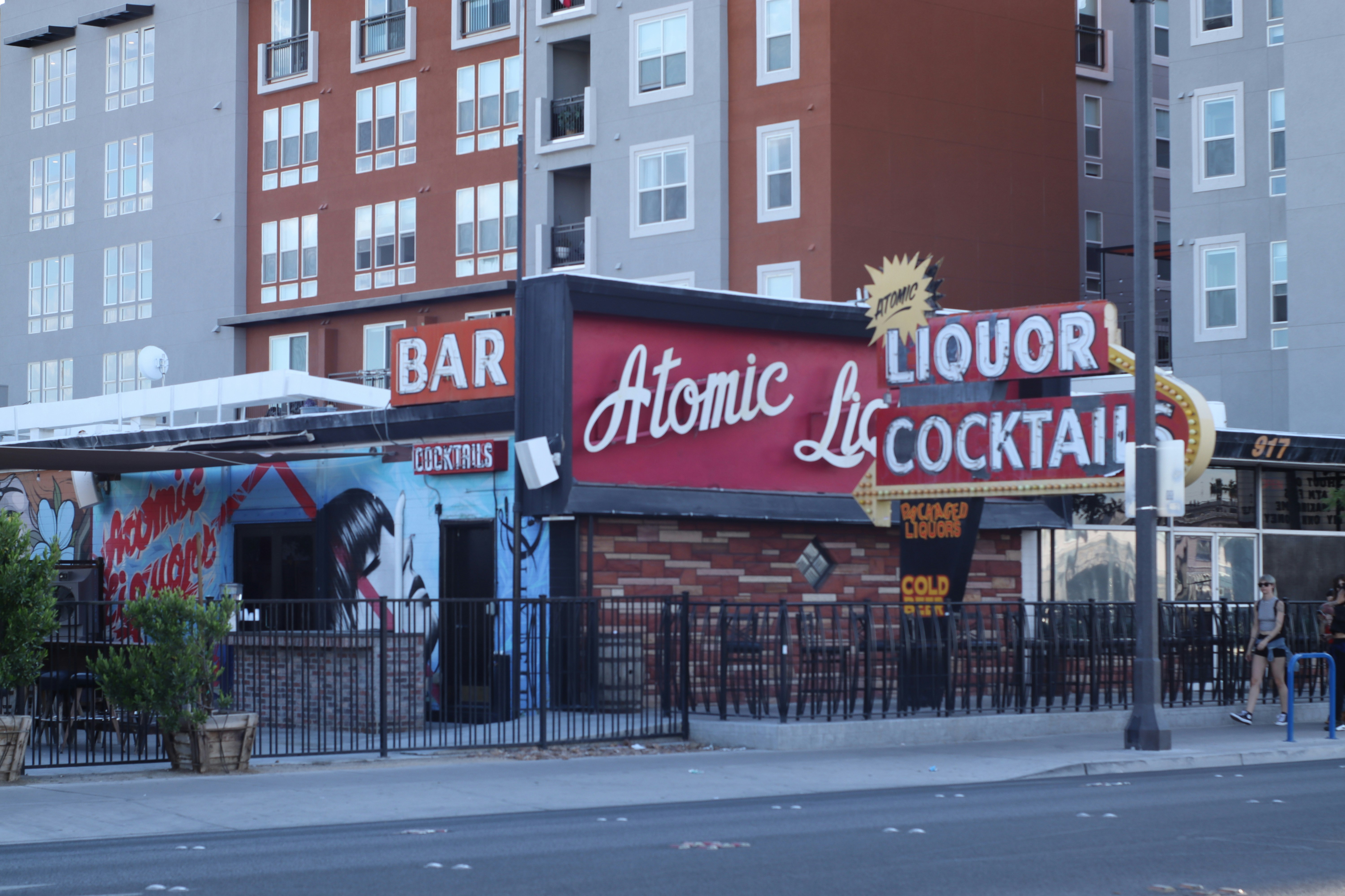 Atomic Neon Sign on a Barfront Framed by Colorful Apartment Facades