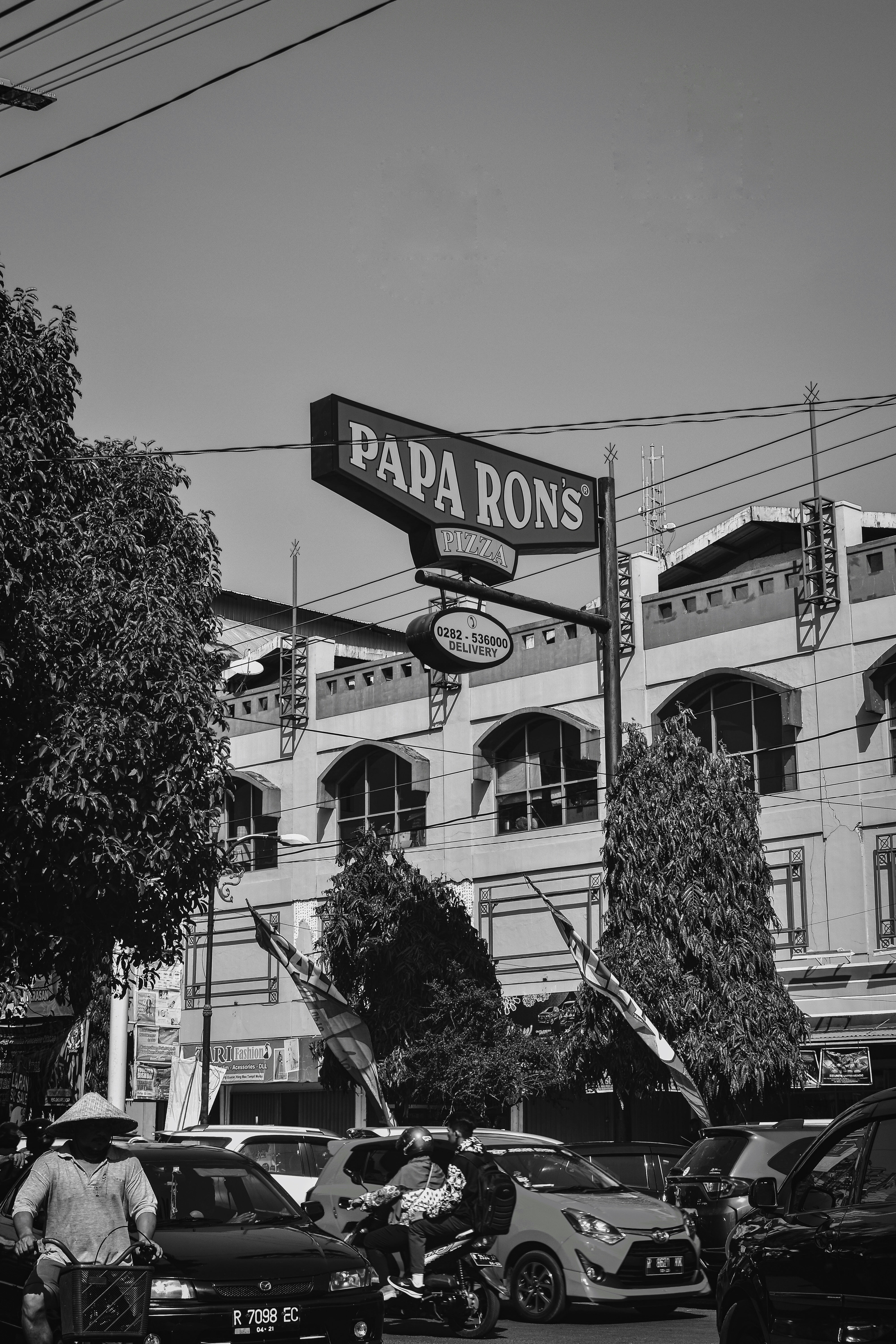 Monochrome Hub: The Papa Don's Sign Over a City Block