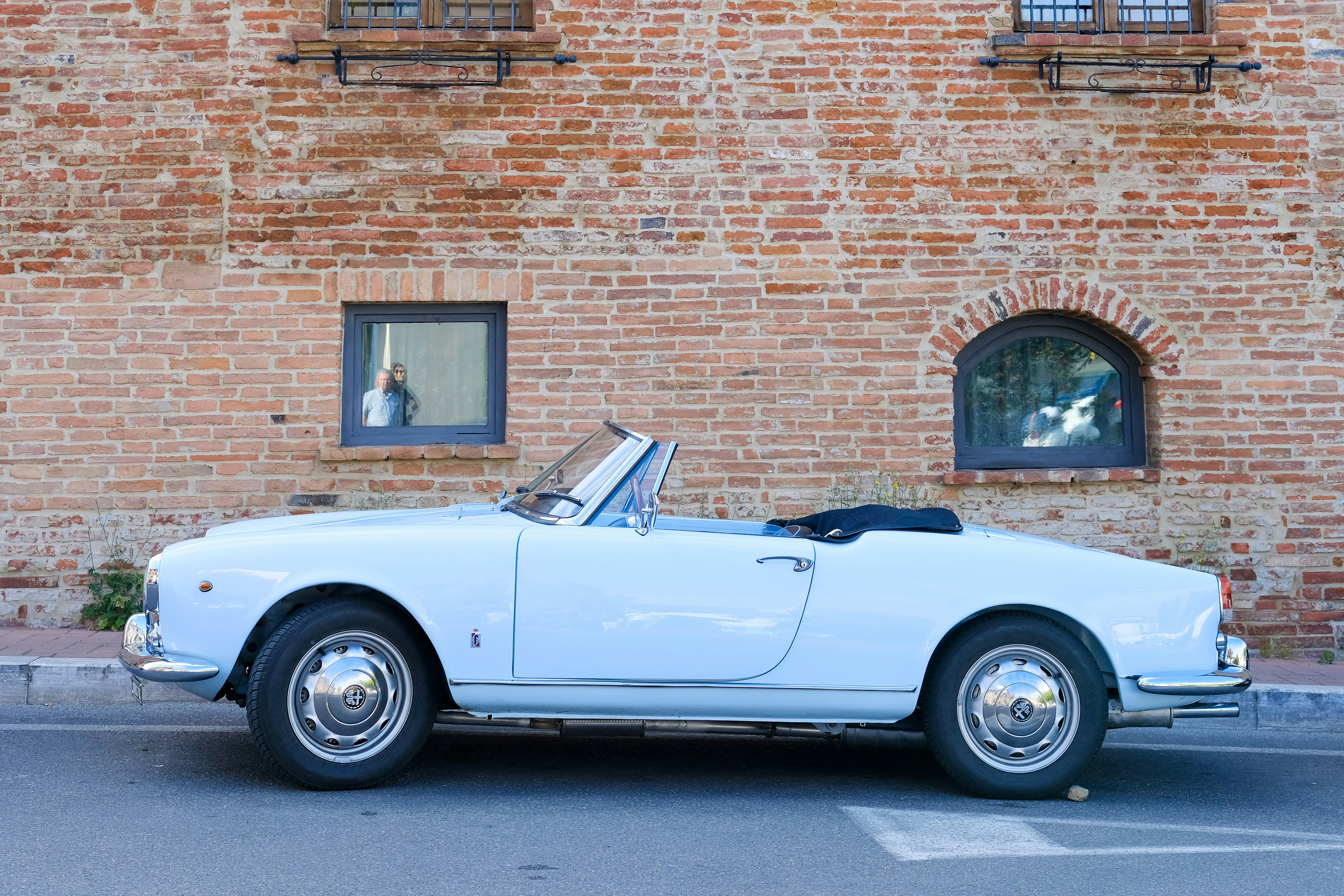 Pastel Roadster Halts Along a Brick-Walled Street