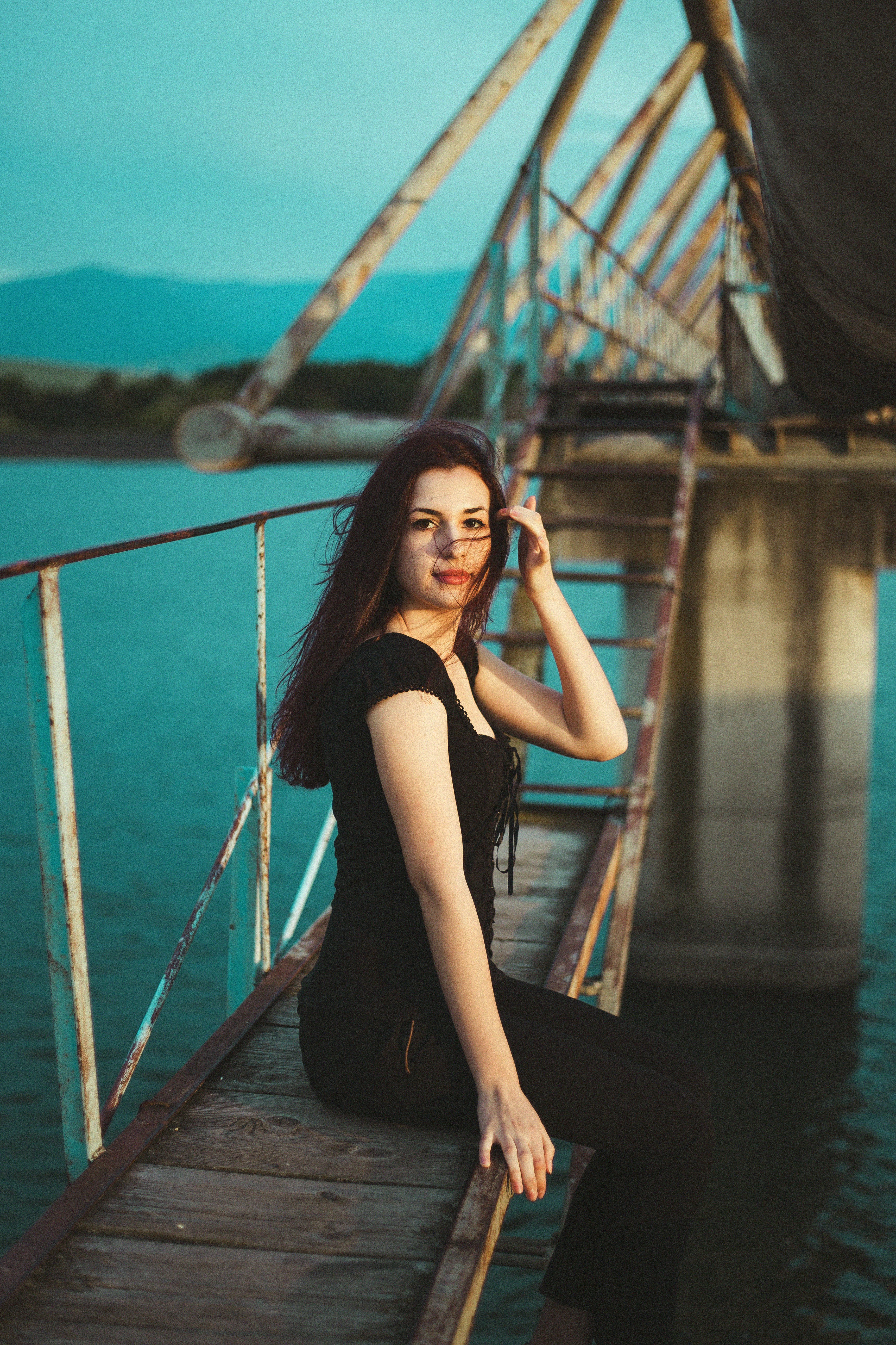 Portrait on a Weathered Waterfront Bridge: Quiet Confidence by Turquoise Waters
