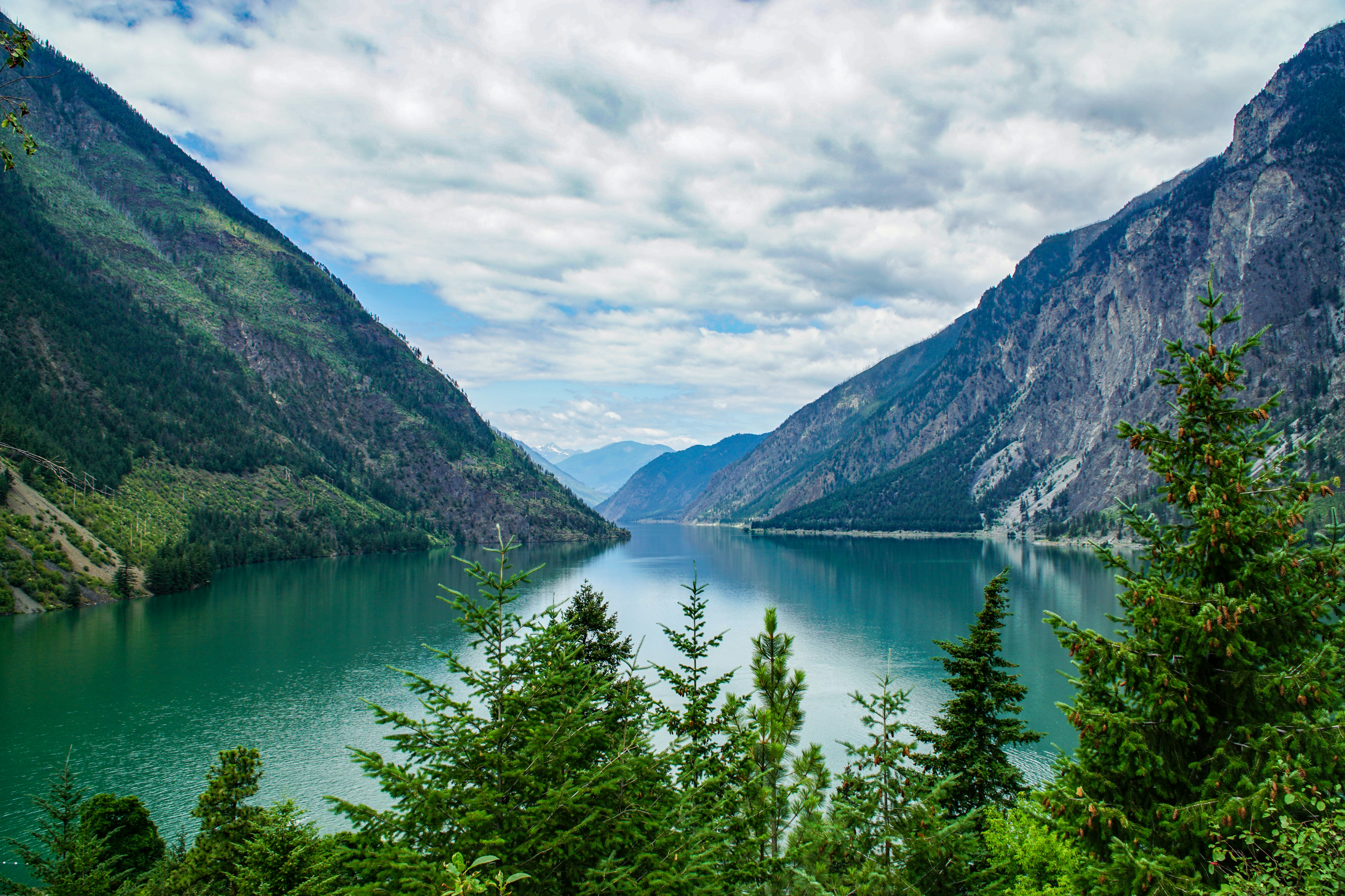 Vibrant turquoise lake framed by majestic mountains and lush greenery, showcasing the tranquility of nature. Ideal for outdoor enthusiasts and landscape lovers.