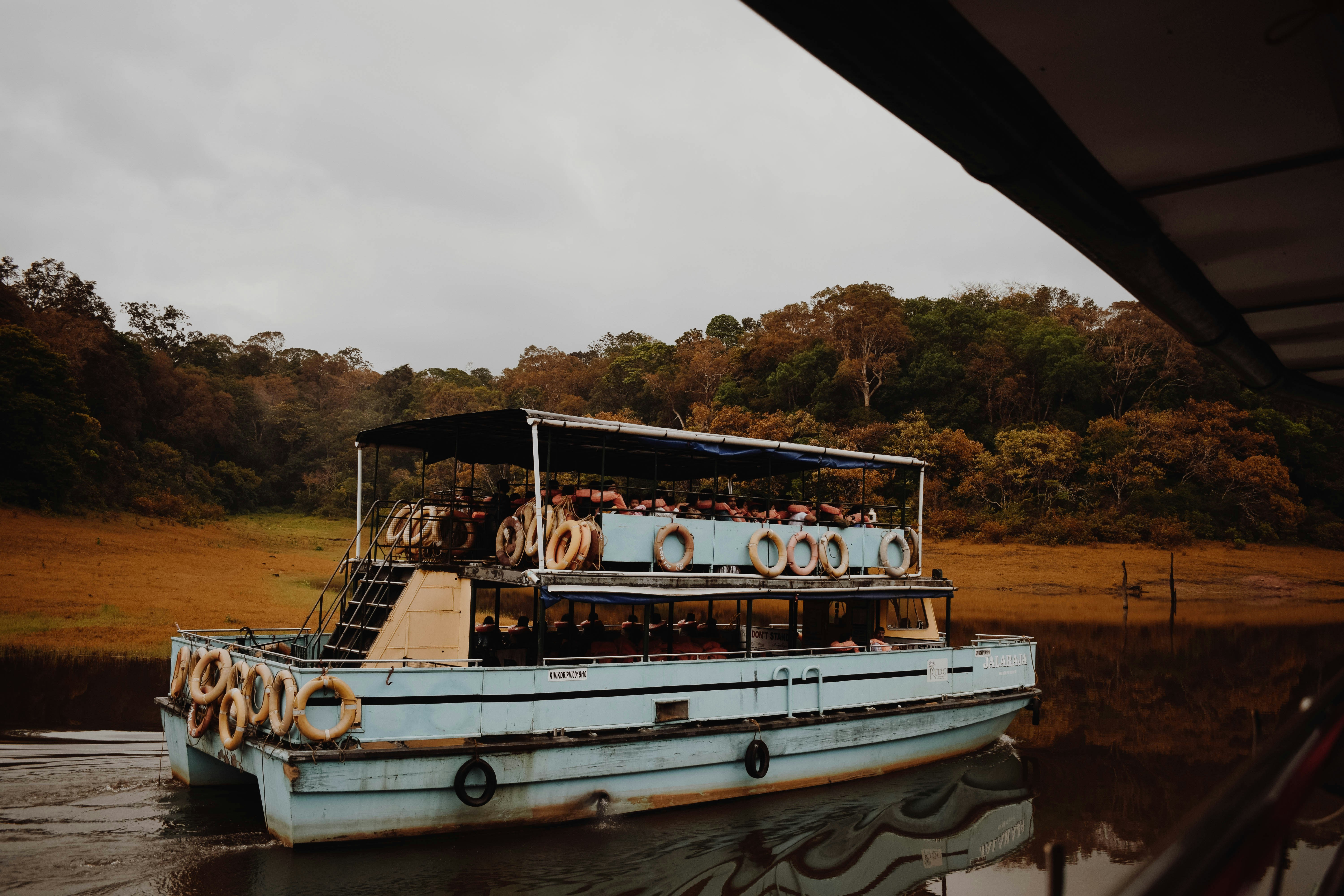 Blue River Ferry Adorned with Tire Cushions Amid Autumn Quiet