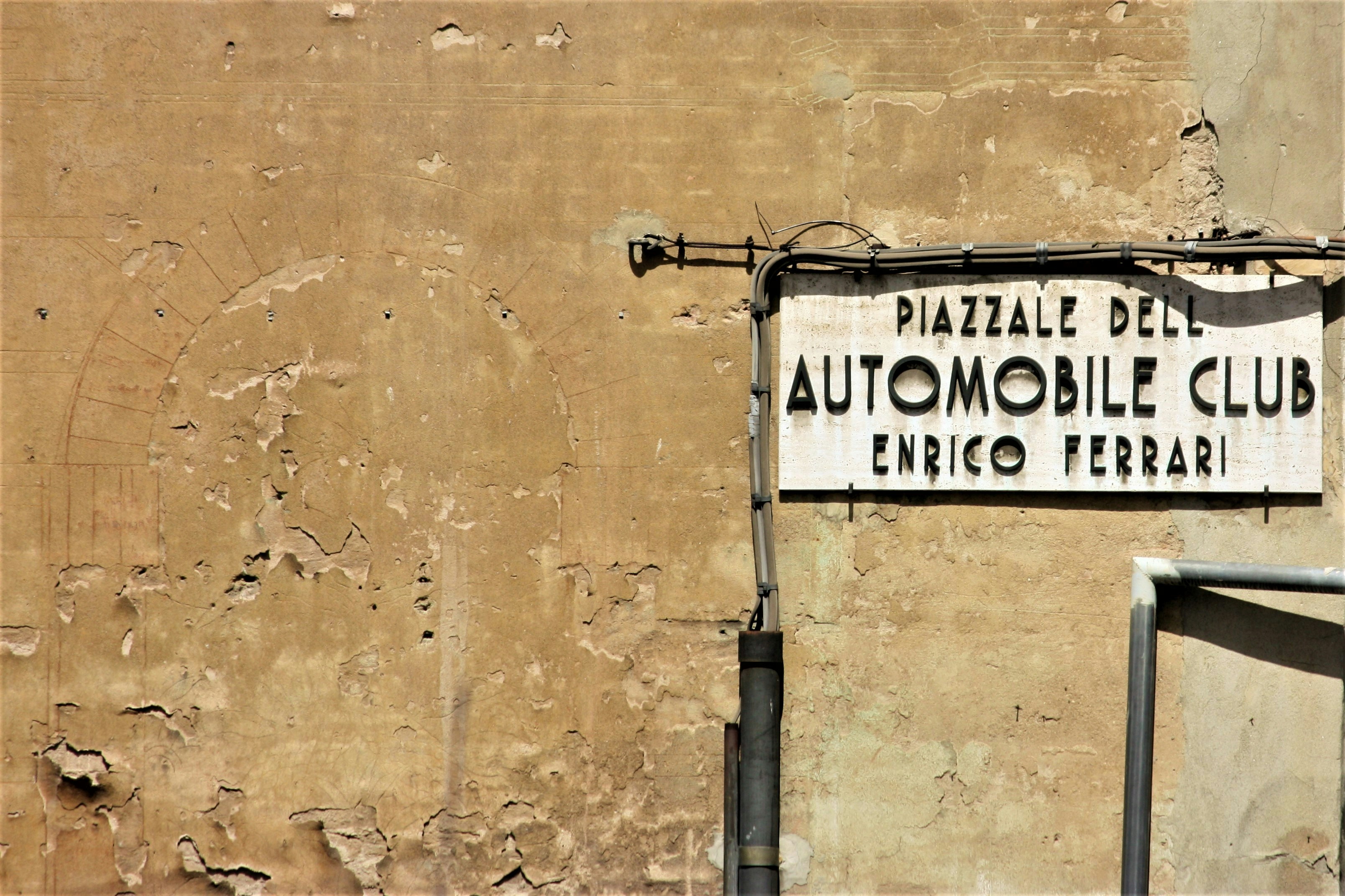 Doorway to a Weathered Sign: Enrico Ferrari on a Crumbling Wall