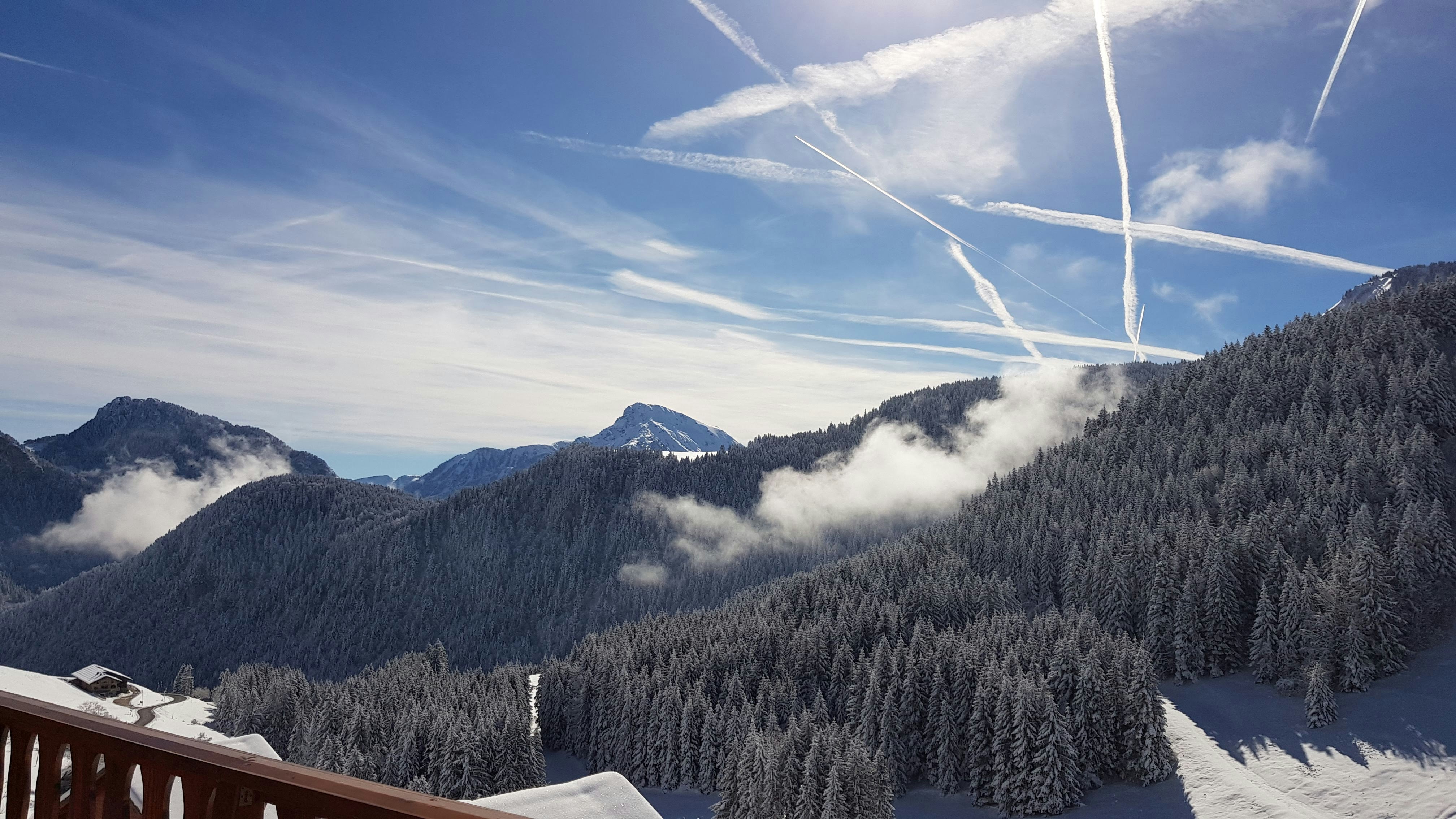 Contrails over a Snow-Laced Alpine Ridge