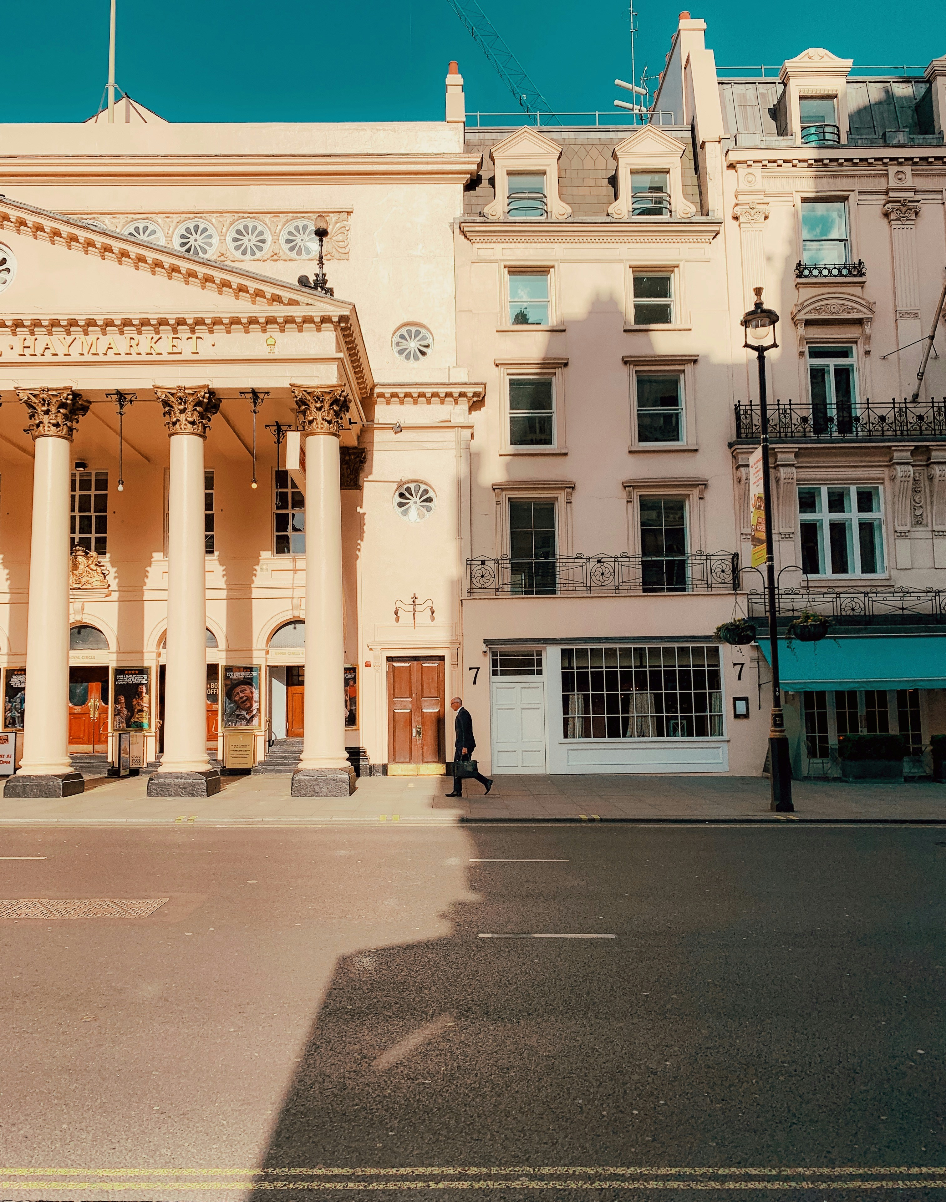 Hombre caminando al lado del edificio durante el día foto – Imagen de Edificio gratuita en Unsplash