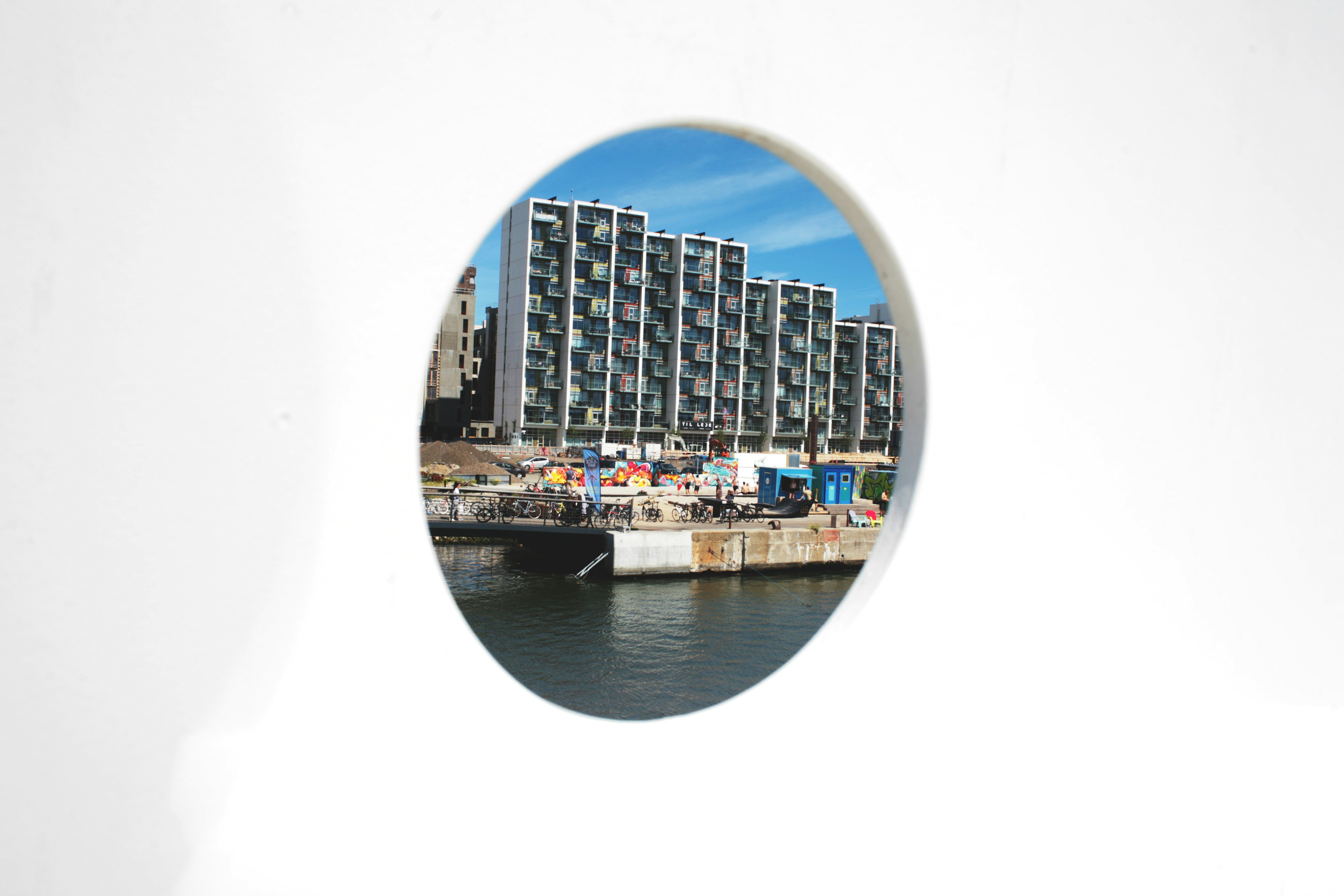 Circular Window to the Harbor: Modern Apartments Framed in White