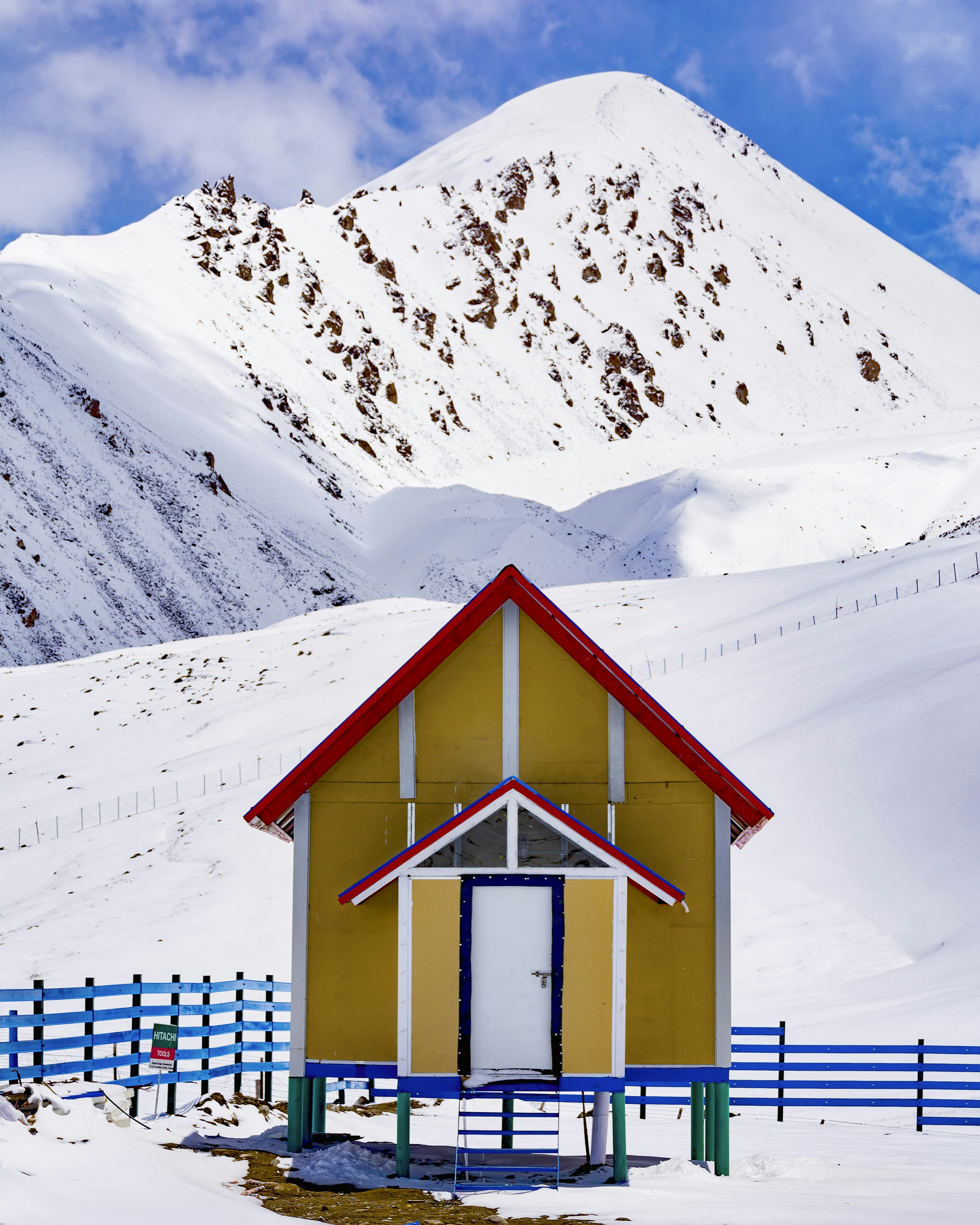 Brown, white, and red hut across white mountain during daytime photo ...