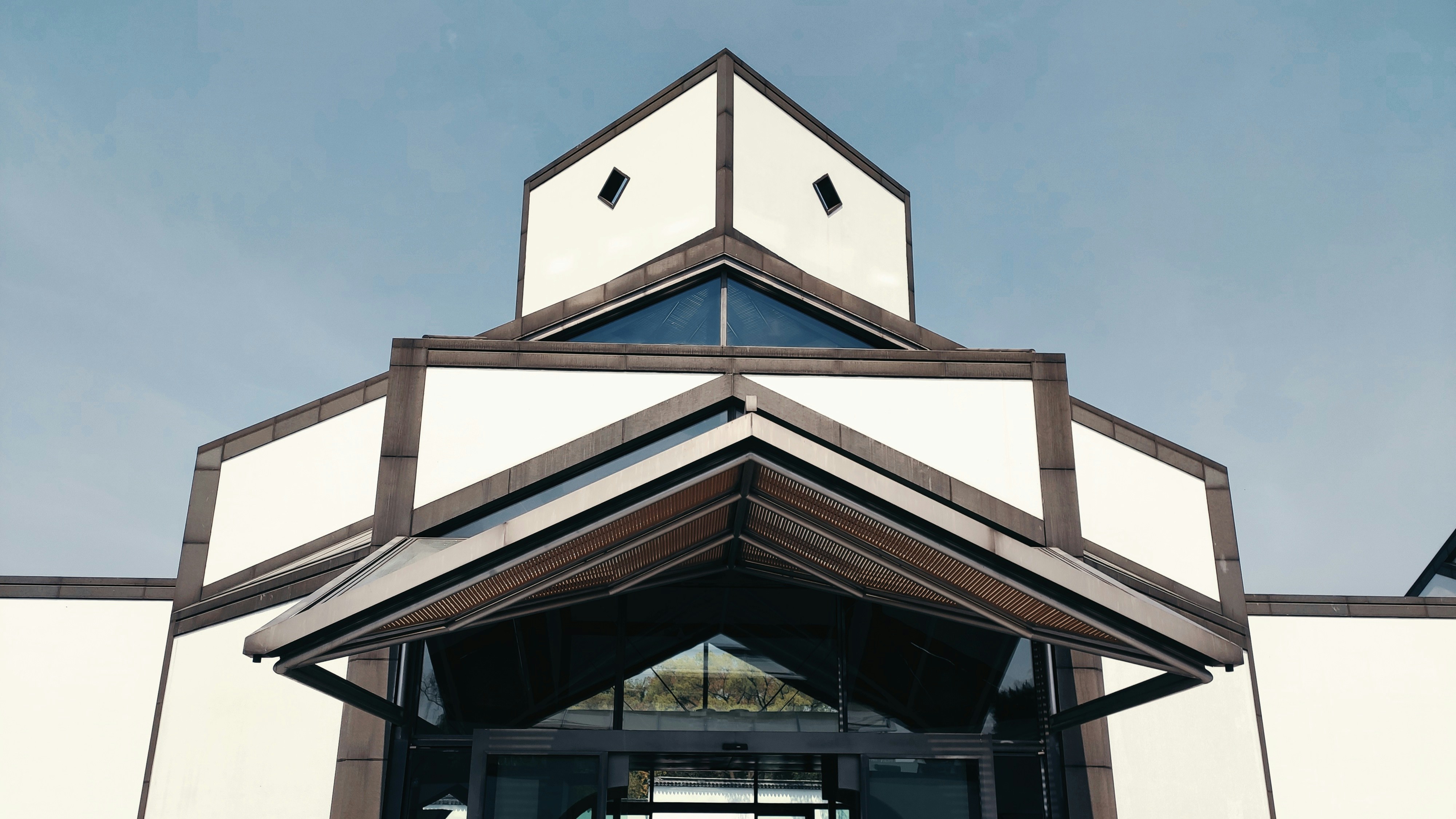 Modern architectural structure with angular lines and contrasting colors under a clear sky.