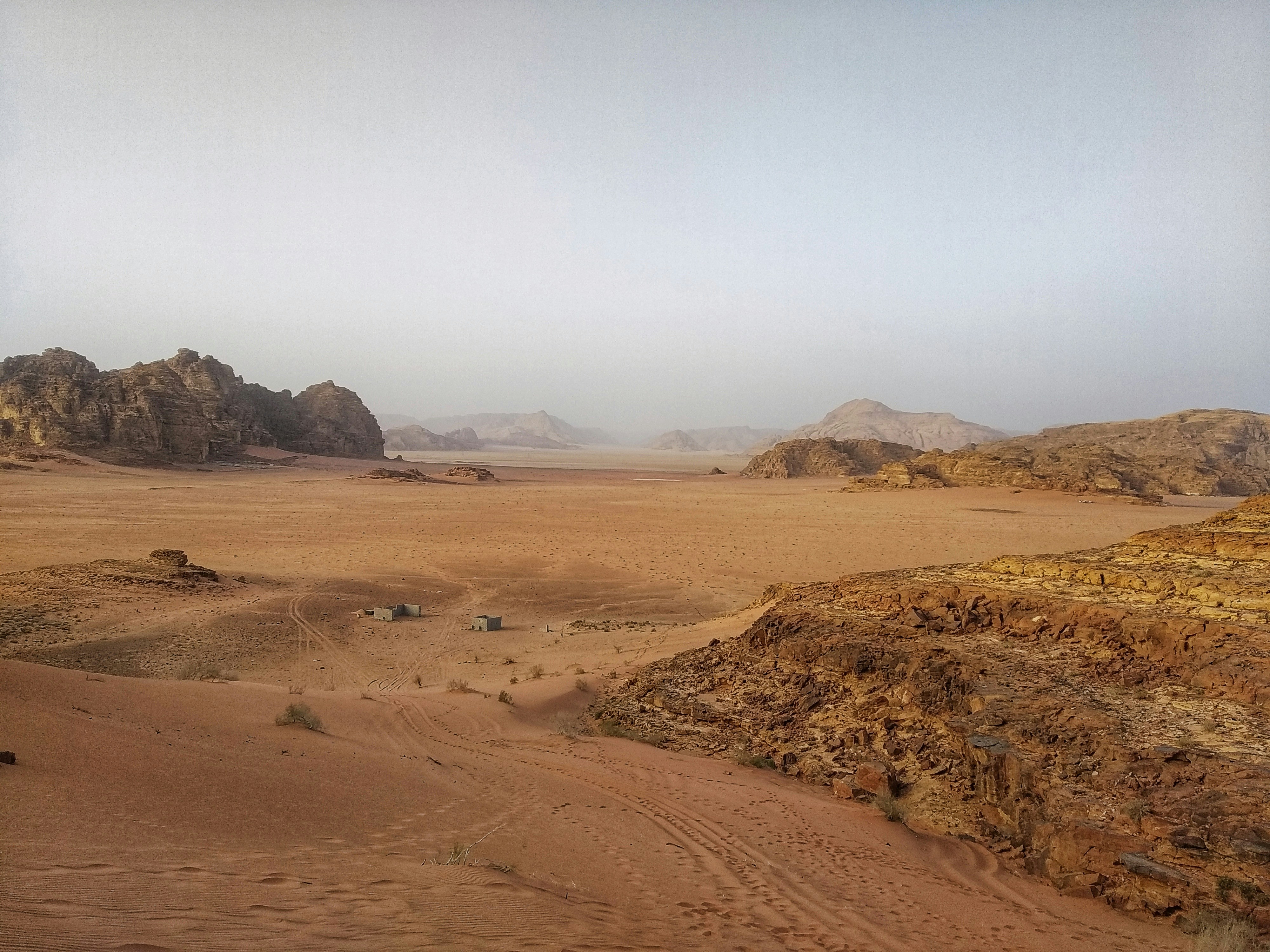 Vast desert landscape with rocky formations under a clear sky in Wadi Rum, Jordan.
