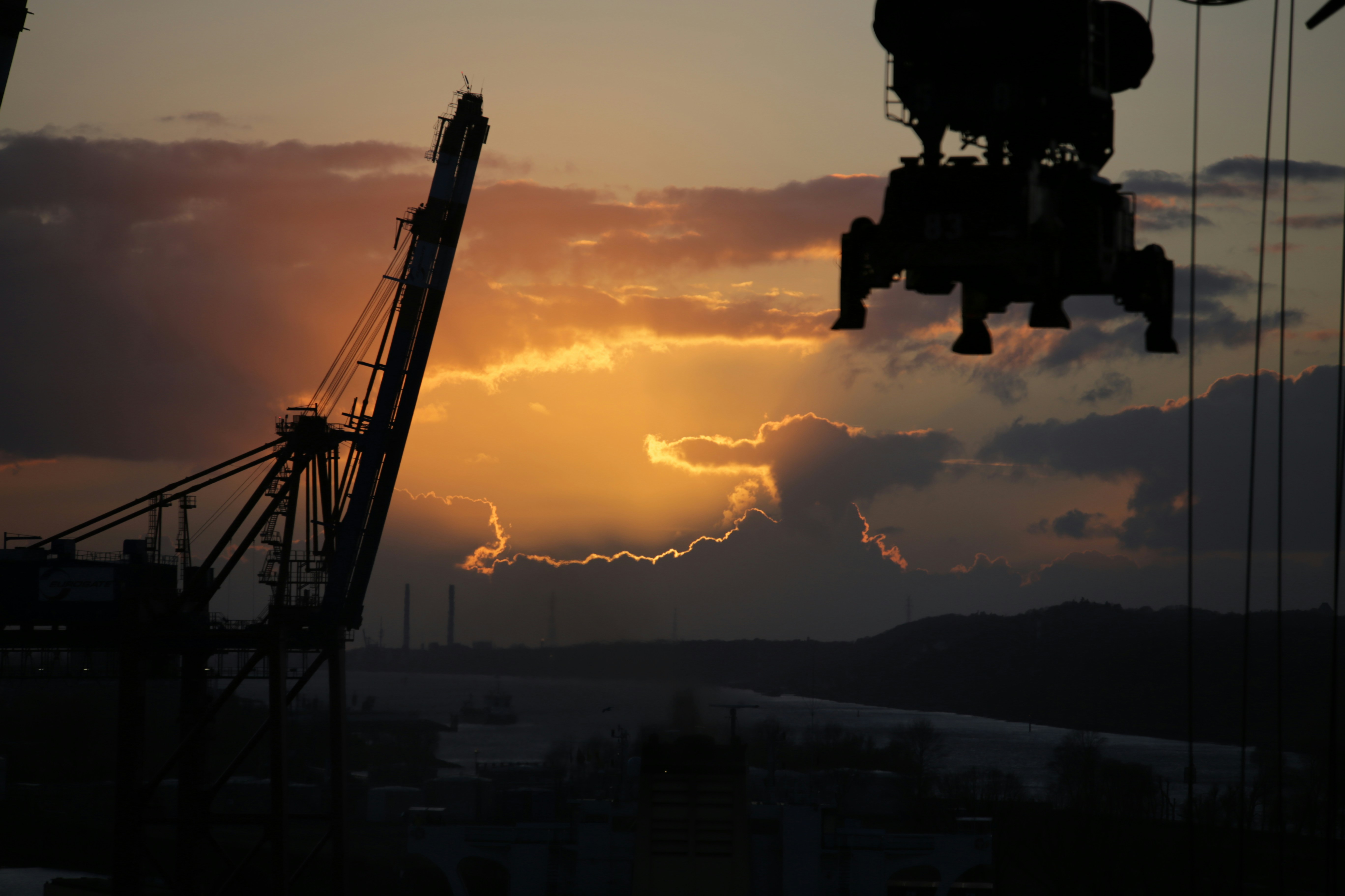 Crane Silhouette at Sunset Over a Quiet Port