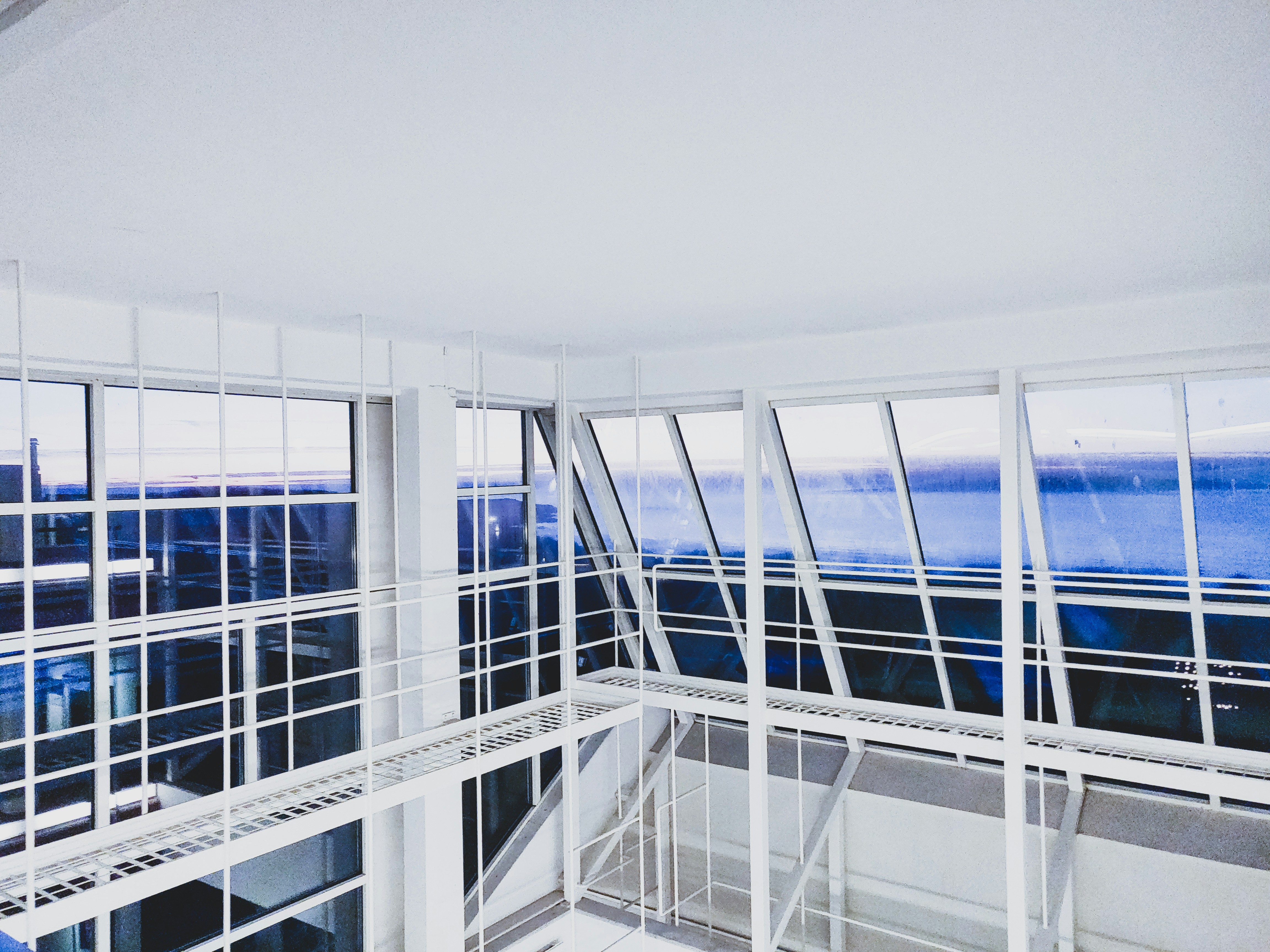 Bright, airy interior featuring geometric lines and expansive windows, showcasing a blend of architecture and natural light.