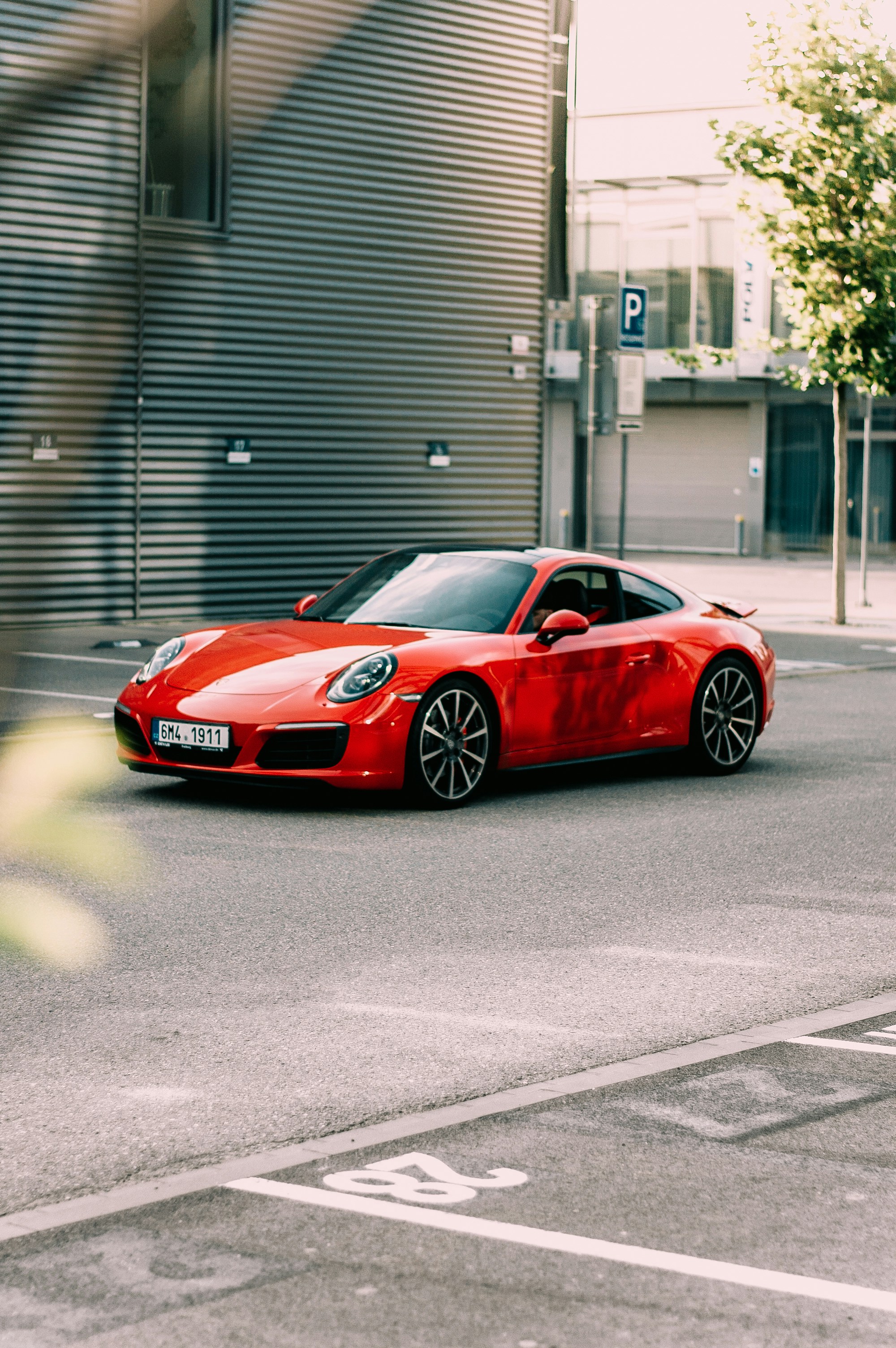 Red coup parked besides gray wall photo – Free Tire Image on Unsplash