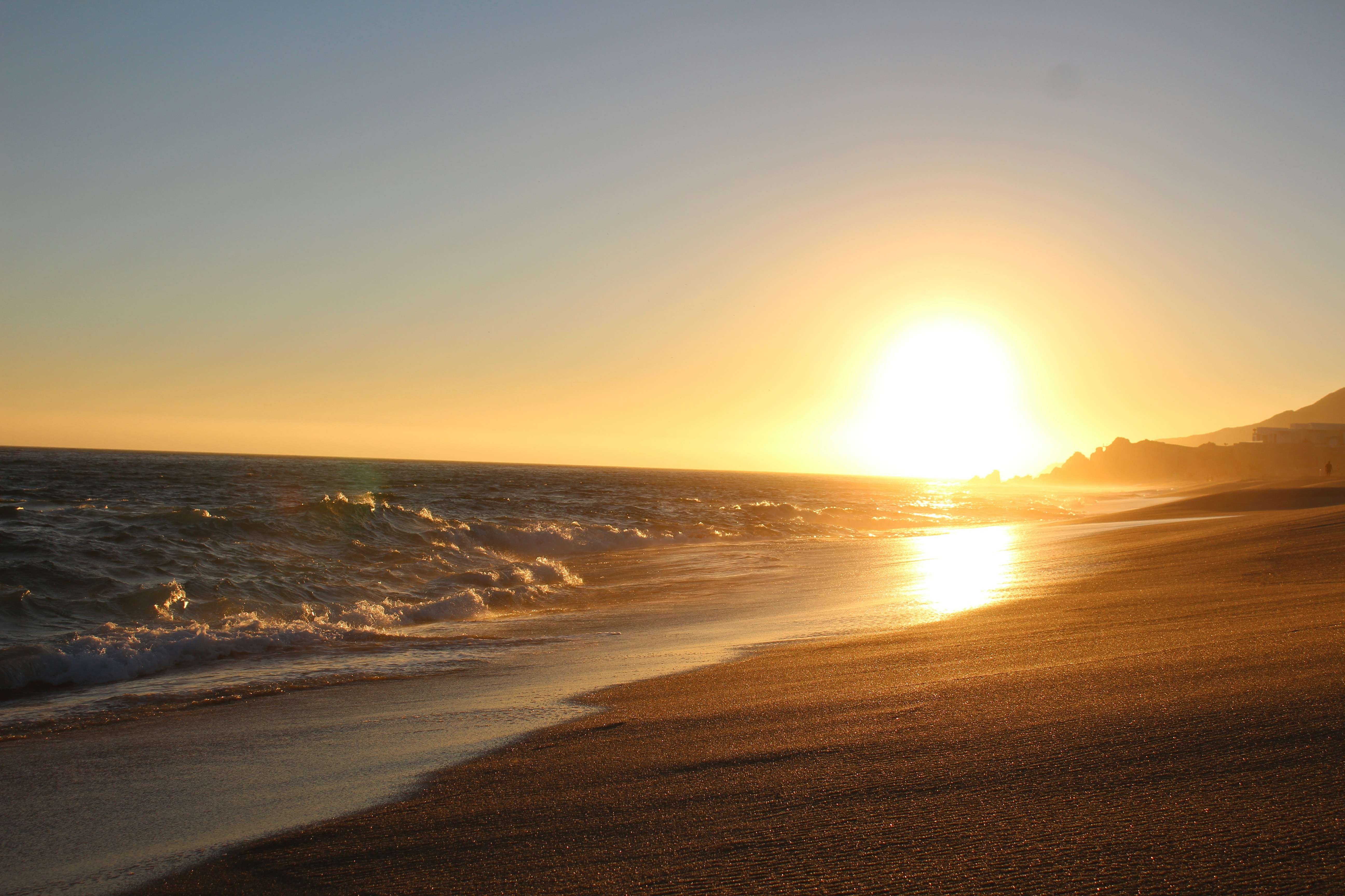 Orange setting sun over brown sand beach photo – Free Nature Image on ...