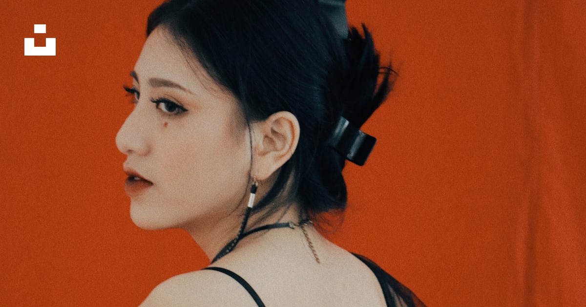 스파게티 스트랩 탑을 입은 여자가 왼쪽을 보고 있습니다 사진 Unsplash의 무료 유행 이미지