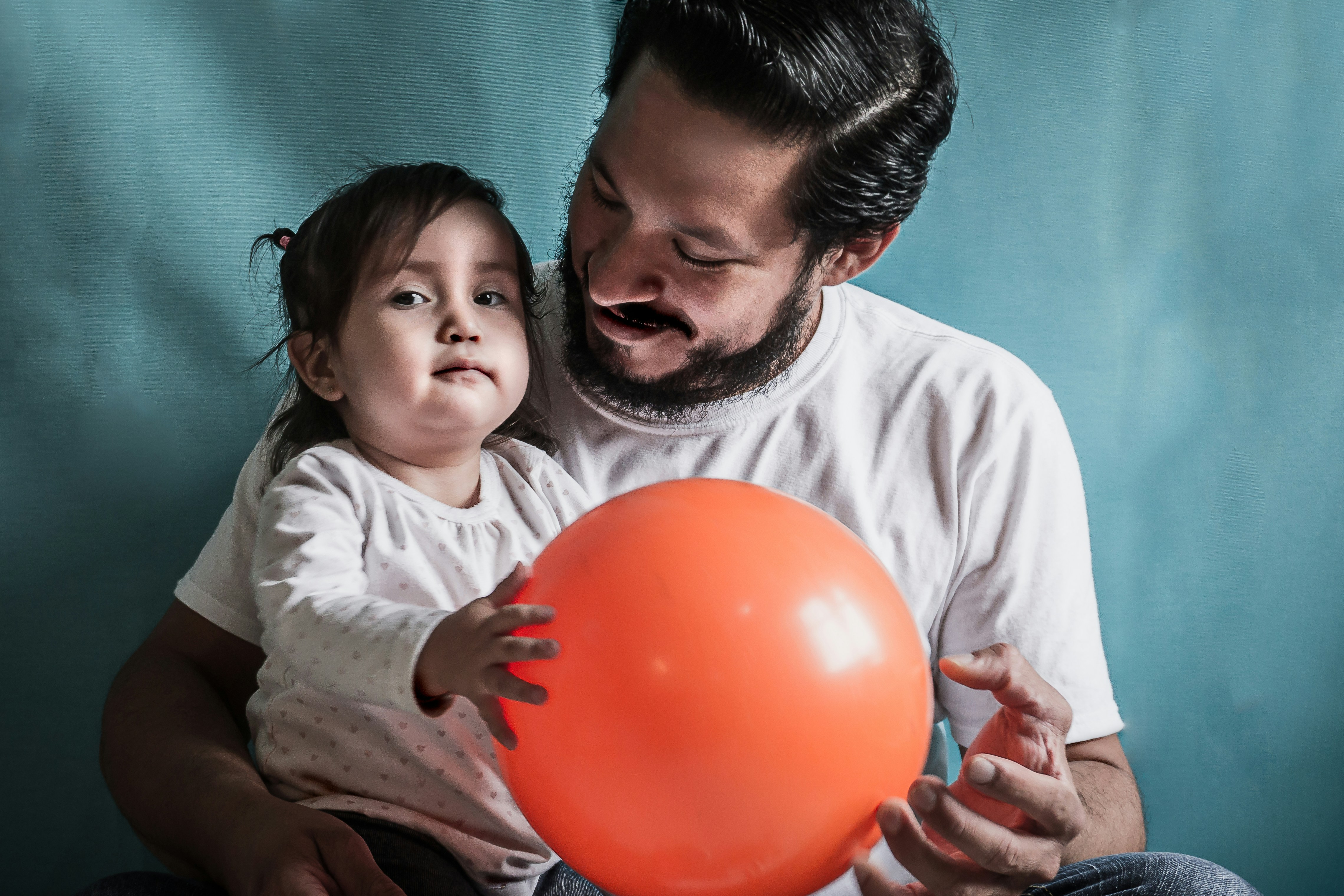 Orange Balloon, Soft Studio Moment: A Father and Daughter in Quiet Joy