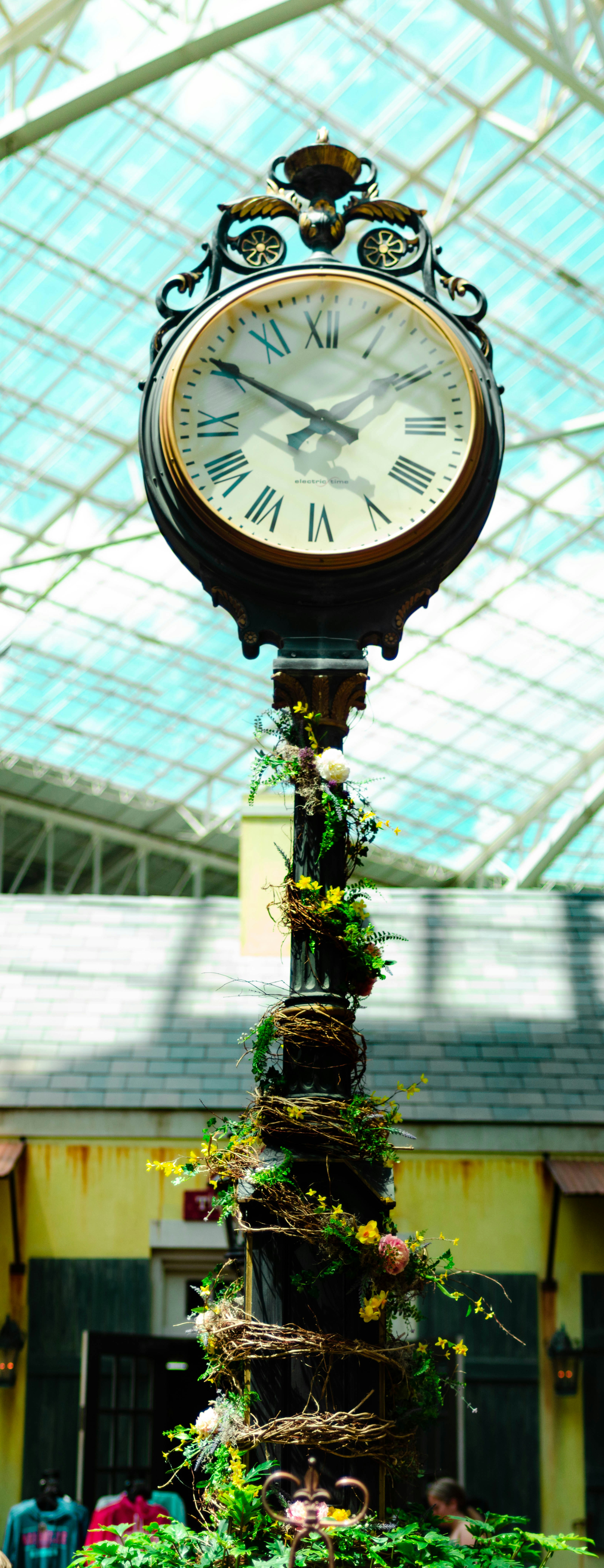 Timekeeper in the Glass Atrium: Ivy-Wrapped Clock with a Gilded Crown
