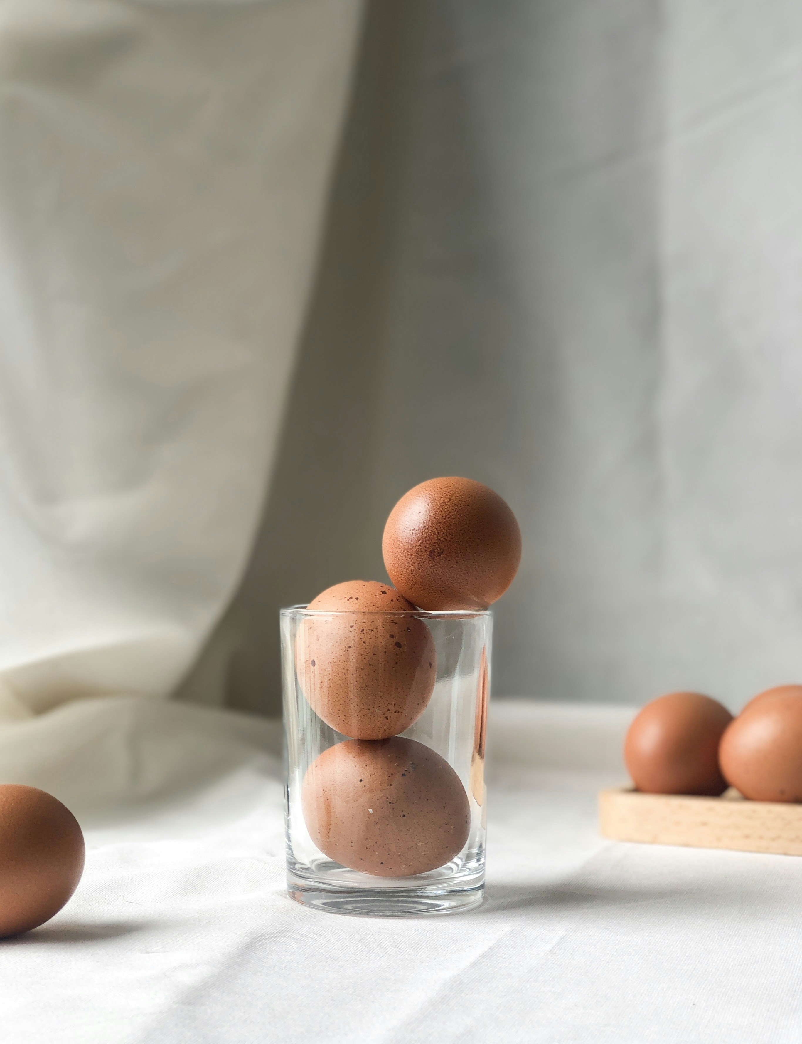 Stacked eggs in a glass: simple still life with soft shadows