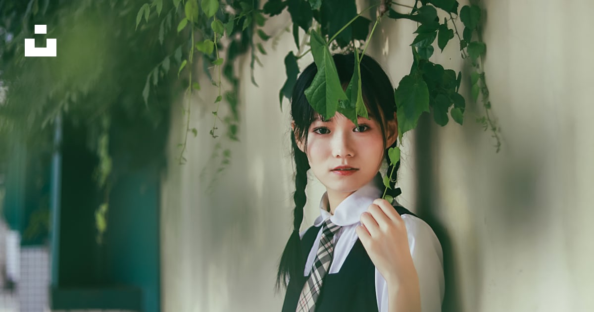 흑인과 백인 교복을 입은 여자가 벽 옆의 녹색 잎이 무성한 덩굴 아래에 서 있습니다 사진 Unsplash의 무료 잎 이미지