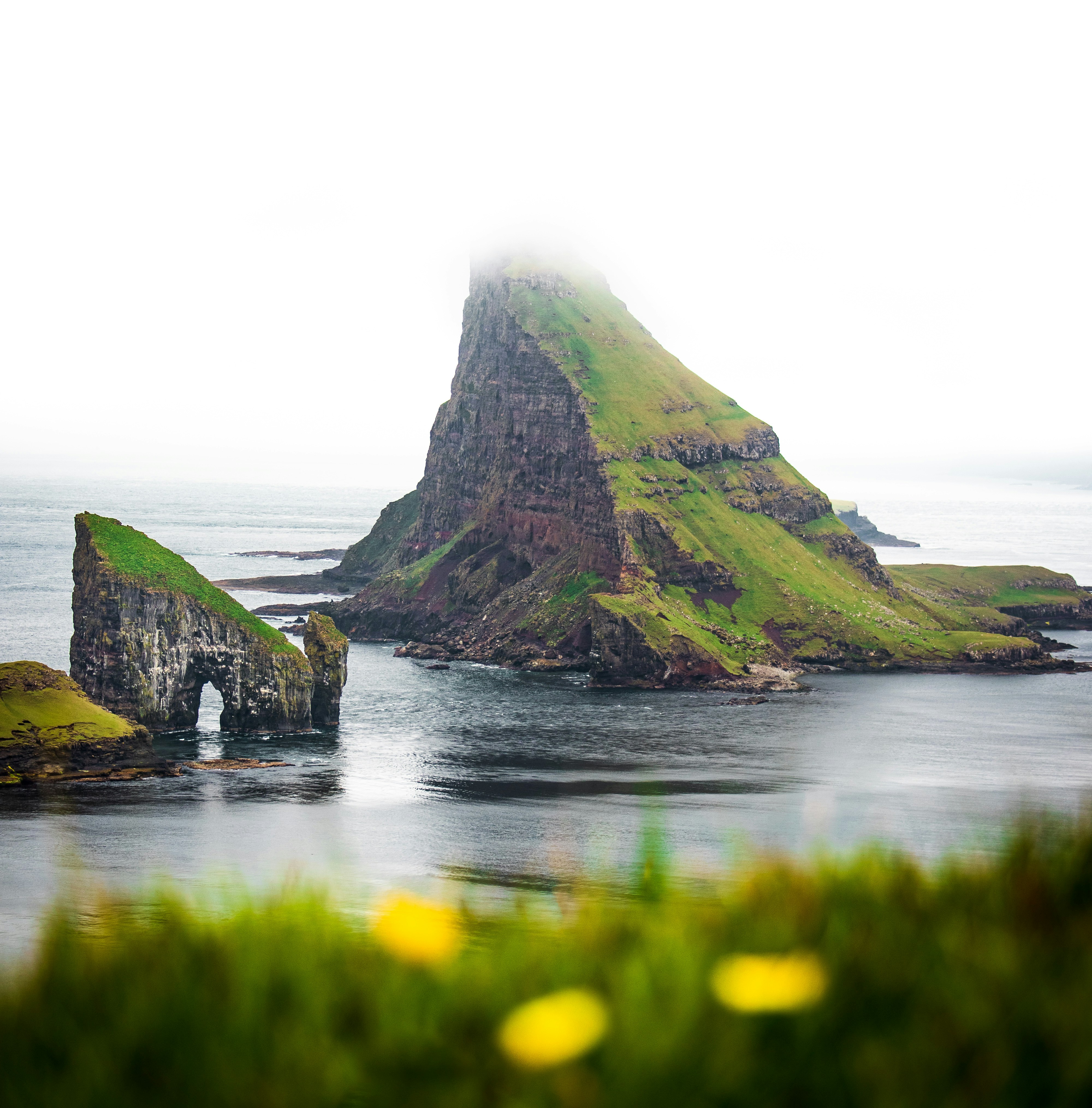 Mist-Softened Isle: A Green Cliff Rising from Calm Waters