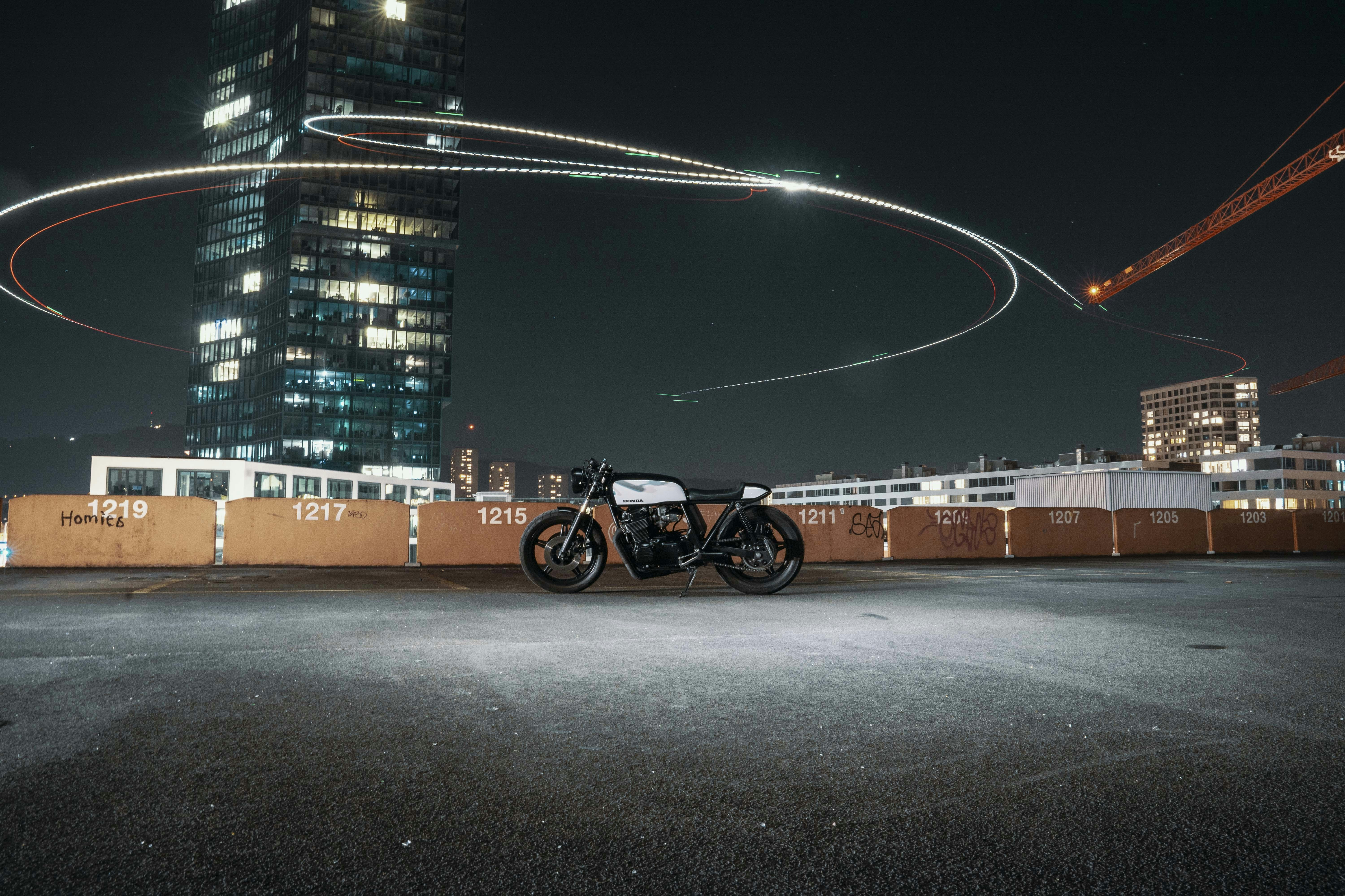 Midnight Ride: A lone motorcycle under looping city lights