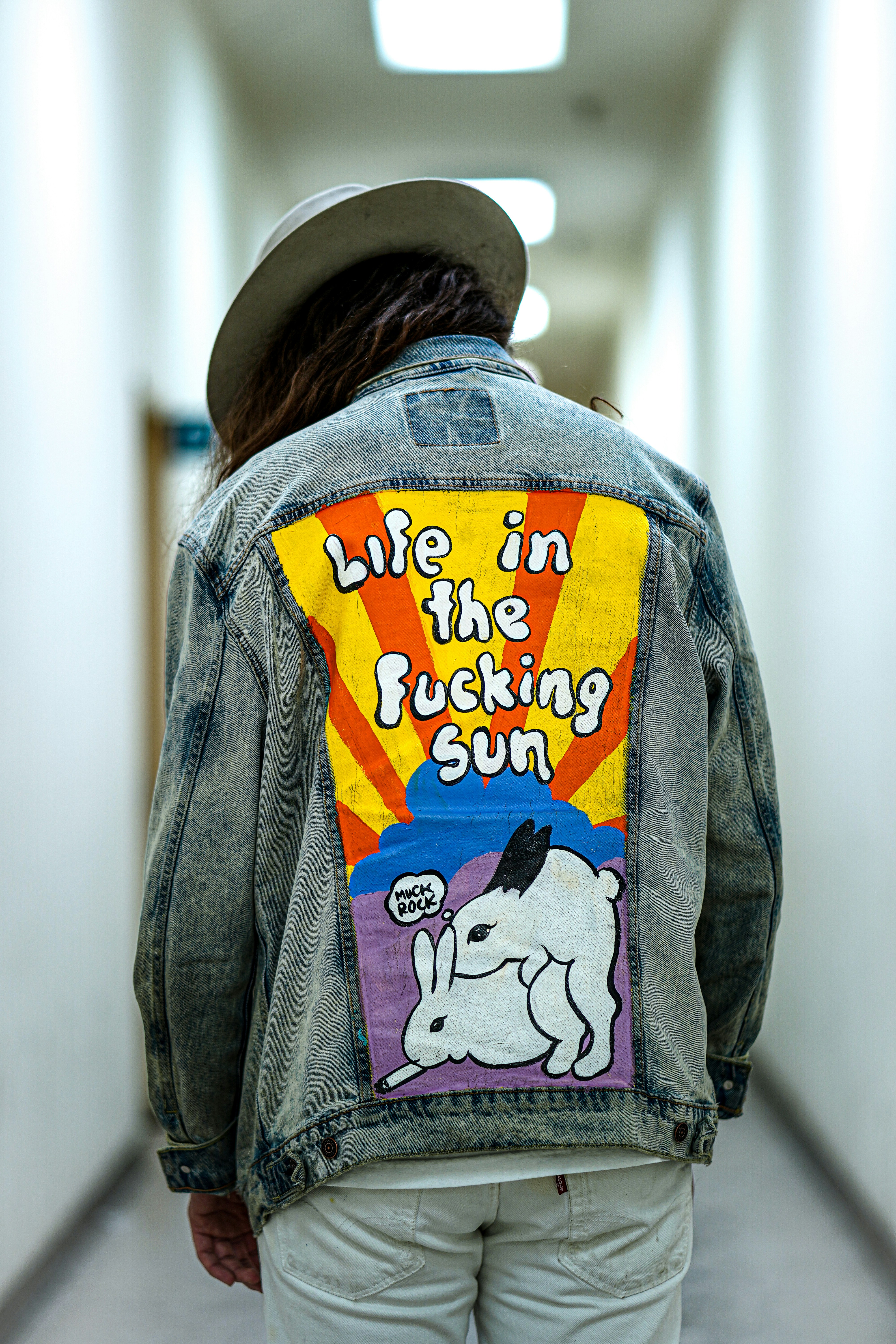 Patchwork Portrait: Denim Jacket Adorned with Bold Street Art