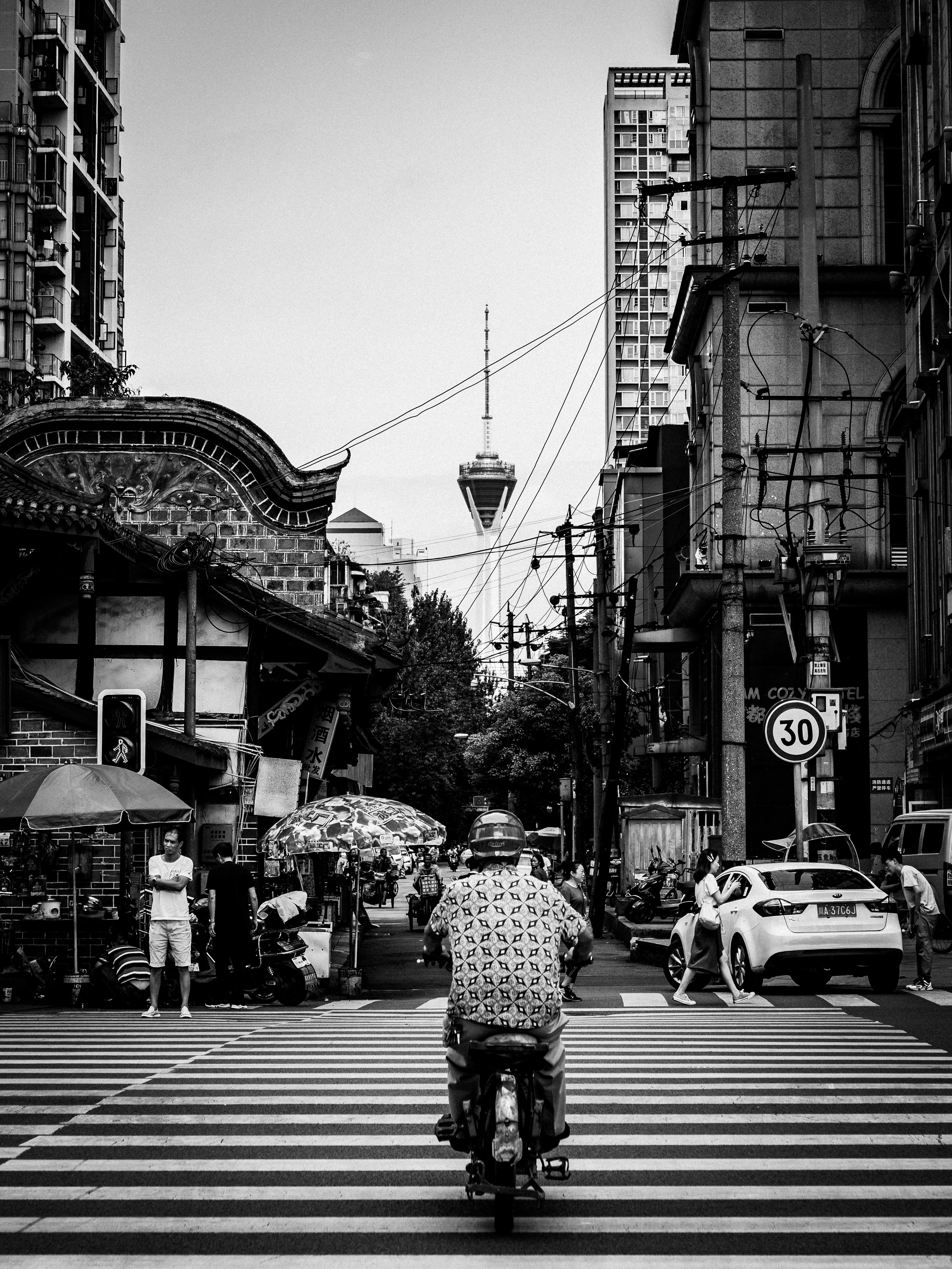 grayscale photography unknown person driving moped