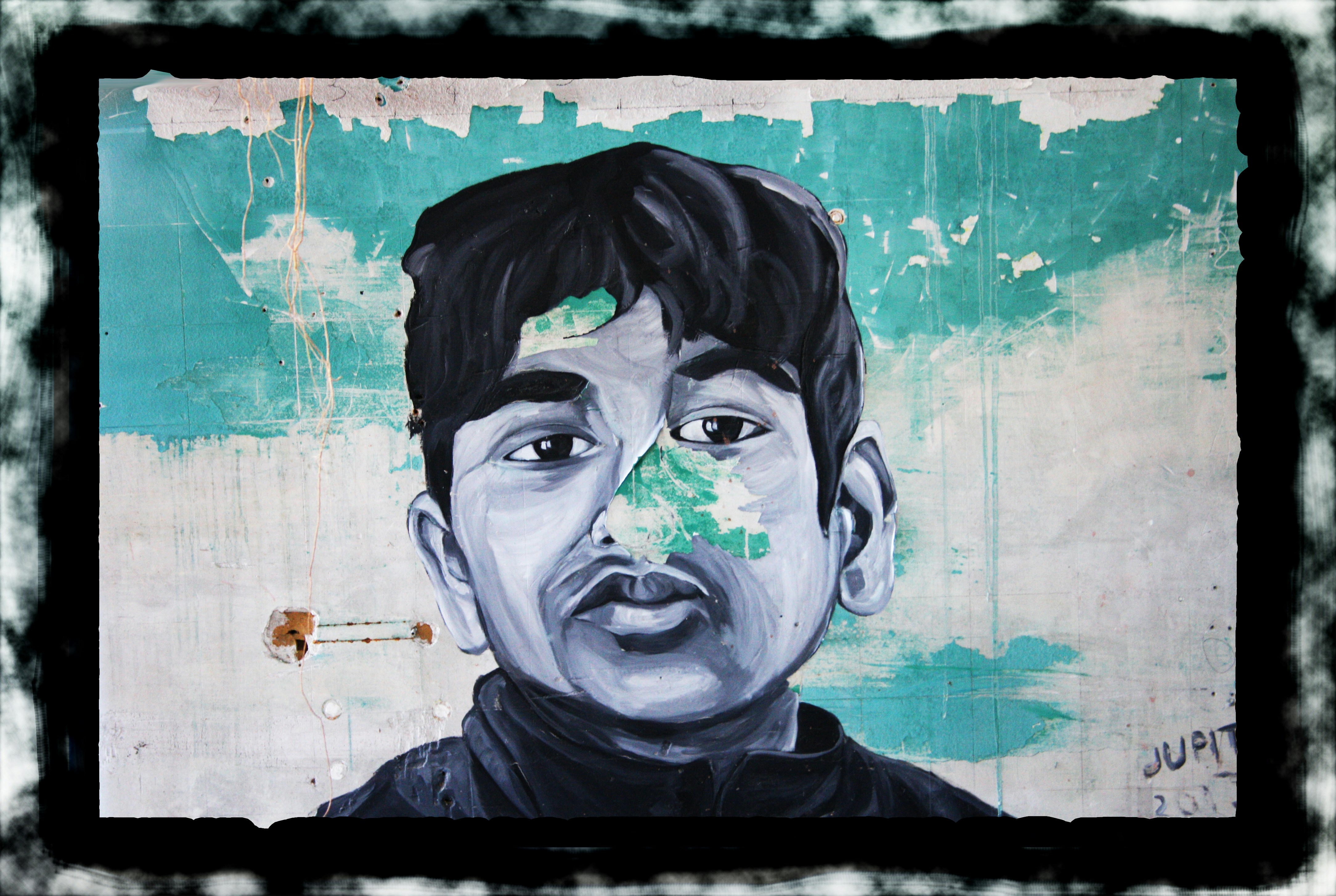 Azure Gaze on a Weathered Wall: Graffiti Portrait of a Boy