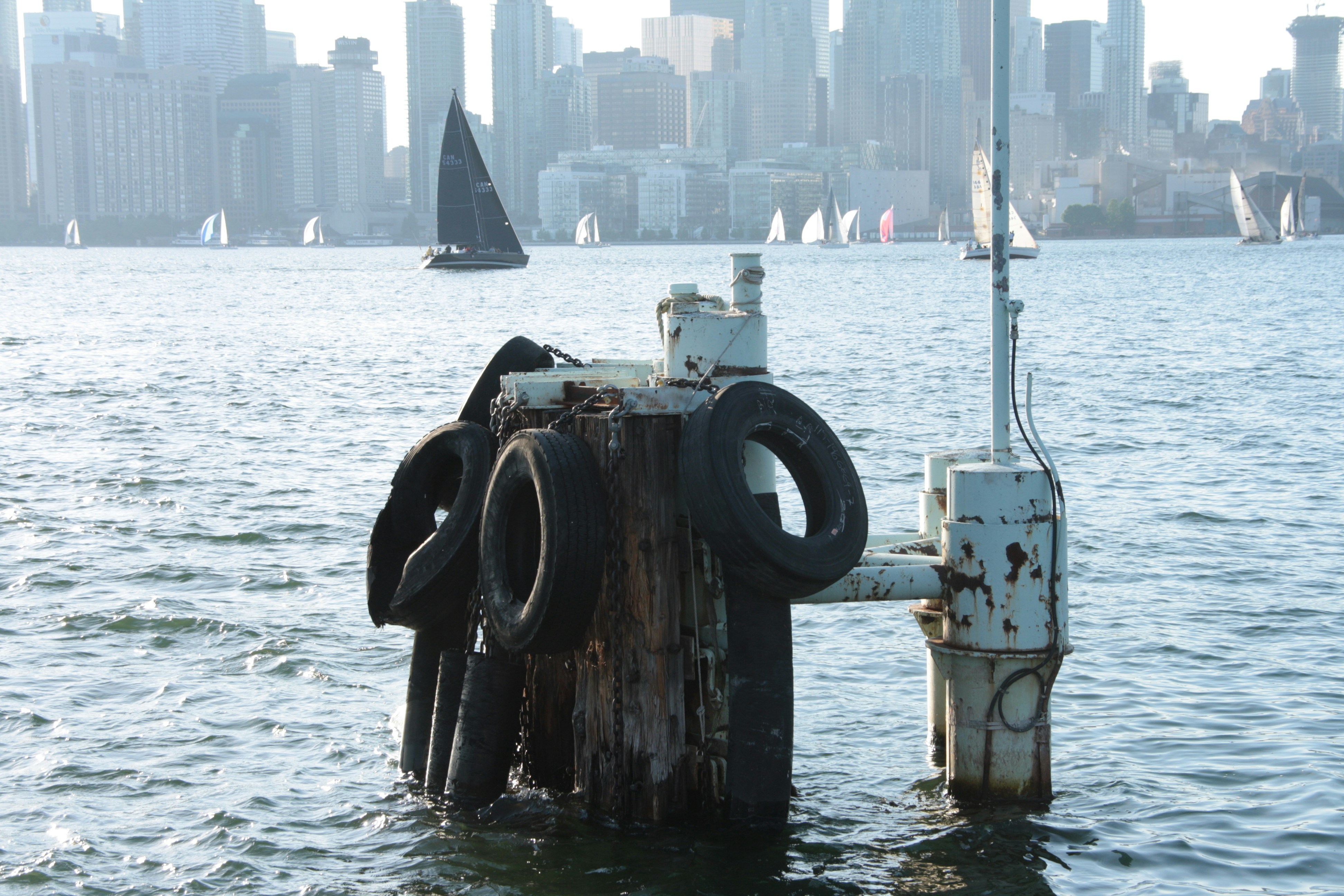 Vehicle tires attached to wooden poles at the harbor photo – Free Boat ...